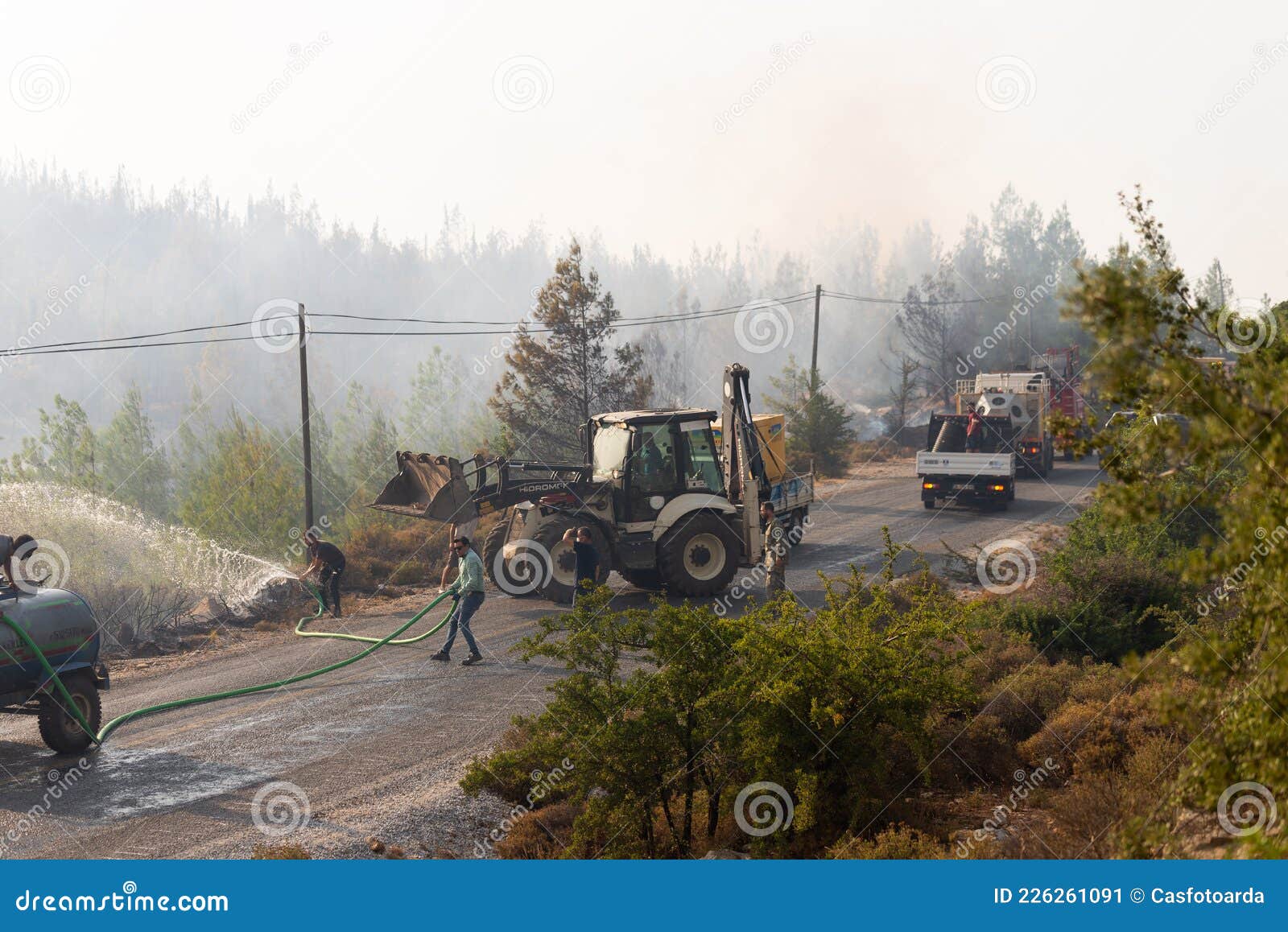Fire Fighting People with Backhoe Loader Trucks and Firetrucks at ...