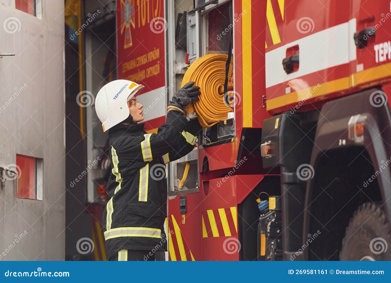 With Fire Hose in Hands. Woman in Uniform is at Work in Department ...
