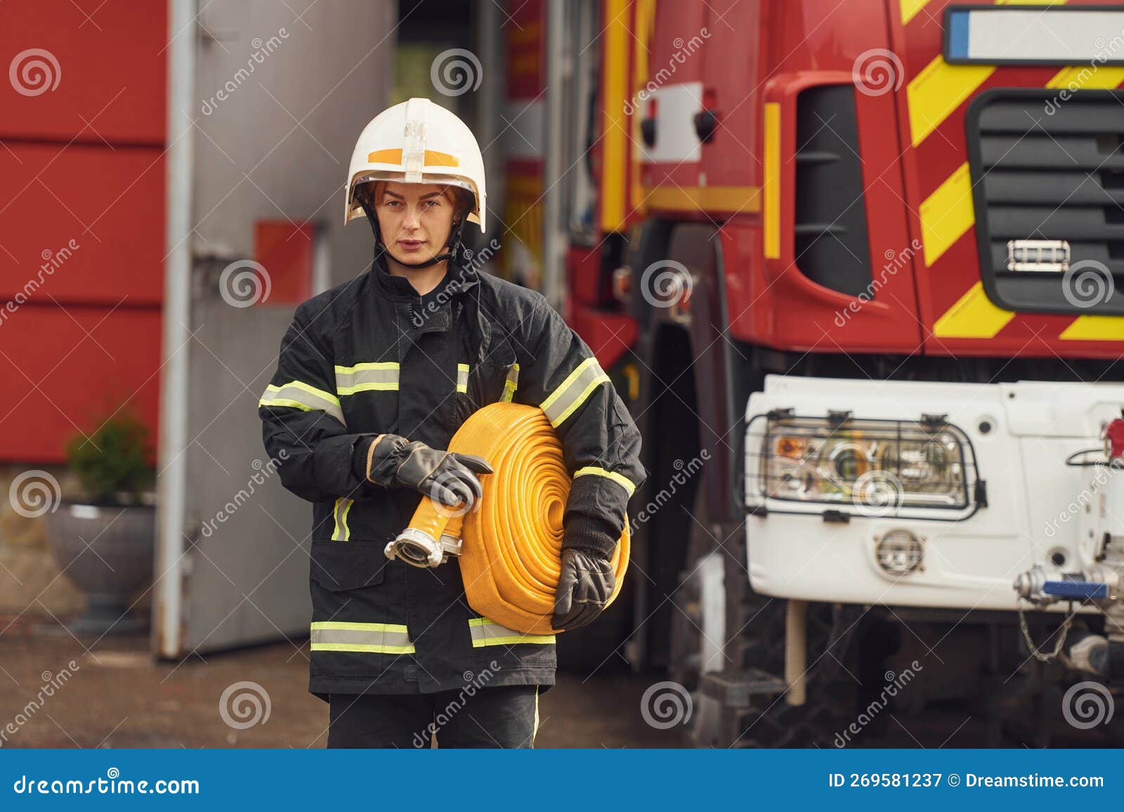 With Fire Hose in Hands. Woman in Uniform is at Work in Department ...