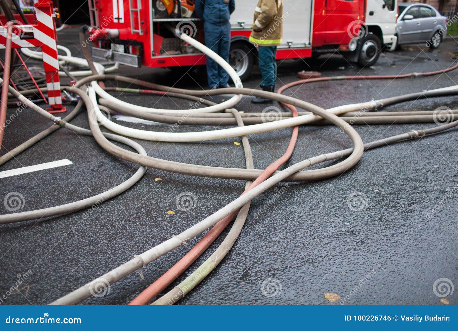 Fire Hoses on the Background of Fire Trucks and Firefighters at Work ...