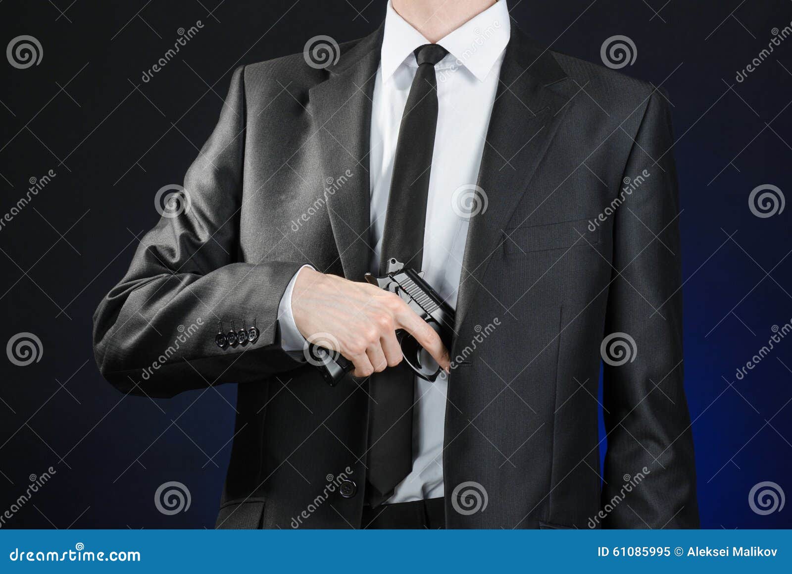 Firearms And Security Topic: A Man In A Black Suit Holding A Gun On An ...