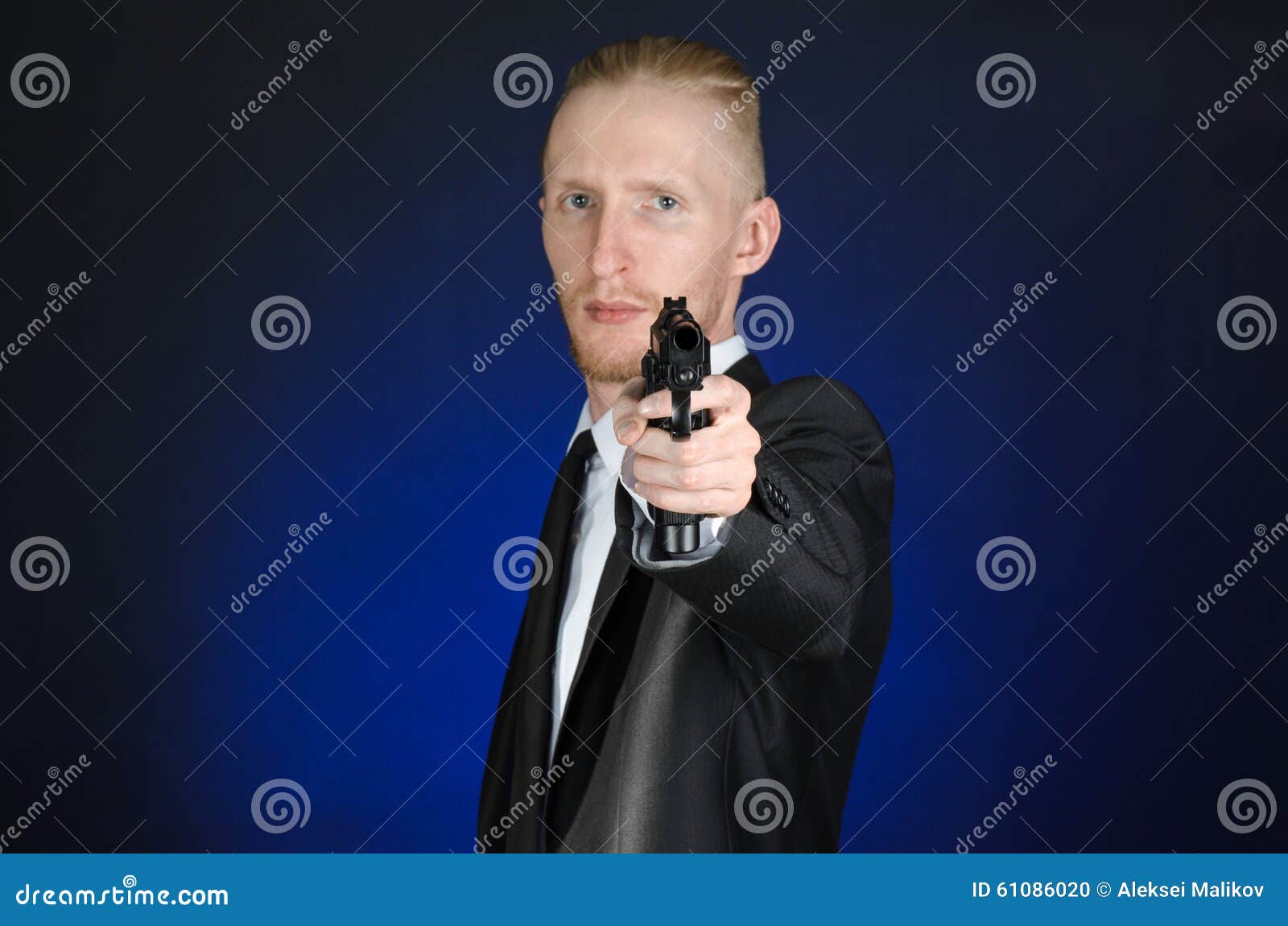 Firearms and Security Topic: a Man in a Black Suit Holding a Gun on a ...