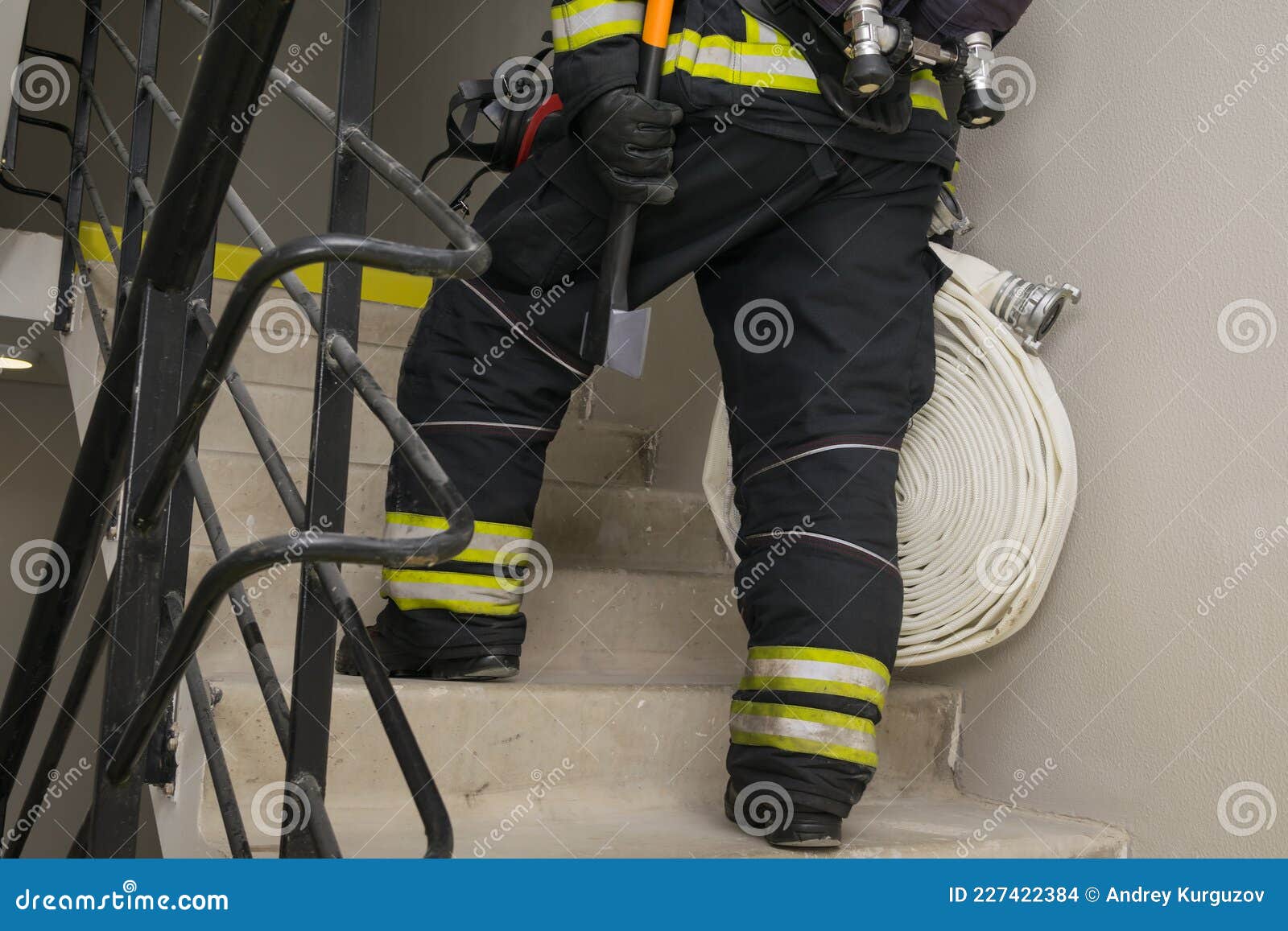 A Firefighter Climbs the Stairs with Equipment for Extinguishing and ...