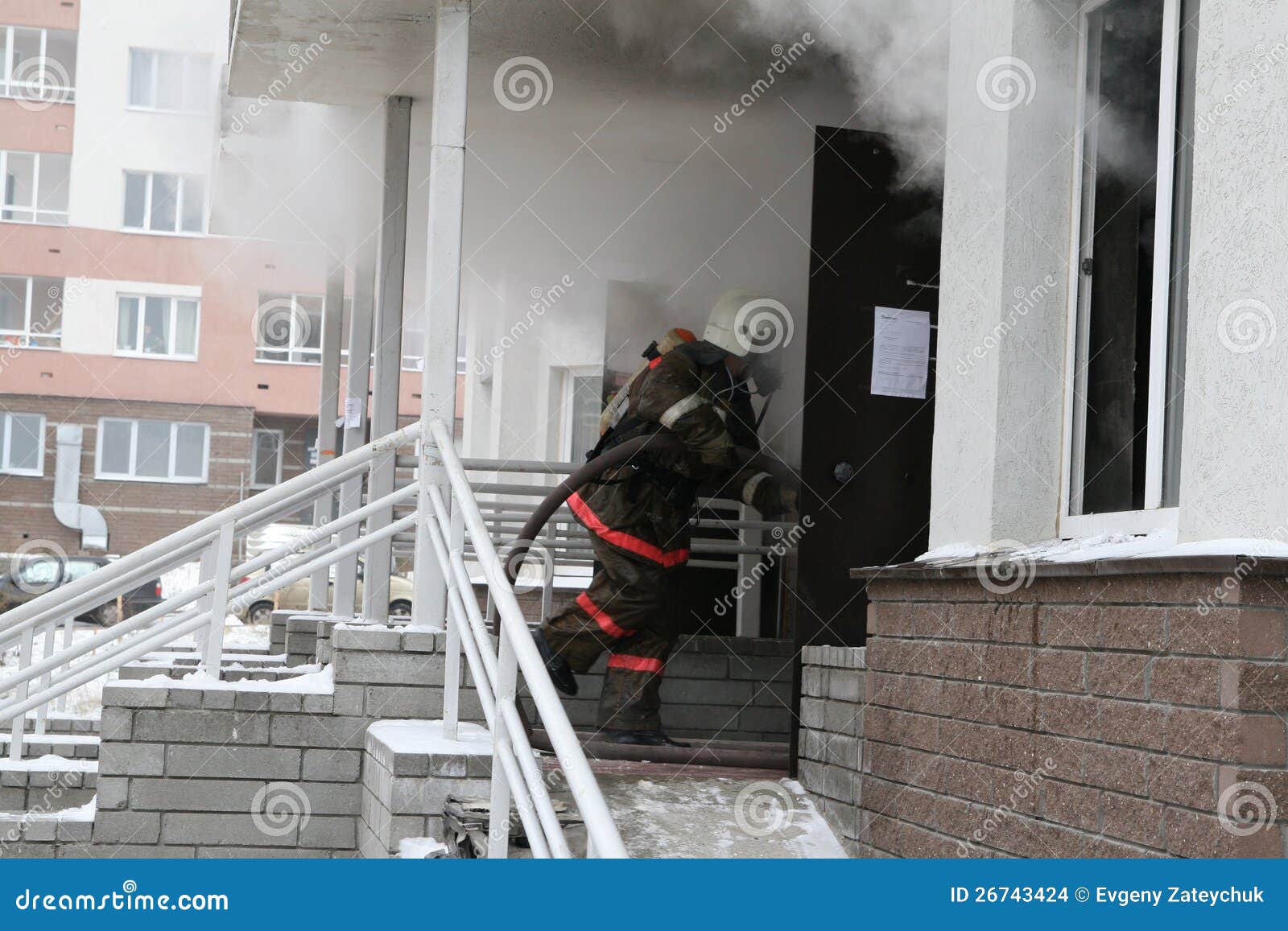 A Man Firefighter Enters The Entrance Of A Multi-storey Building To ...