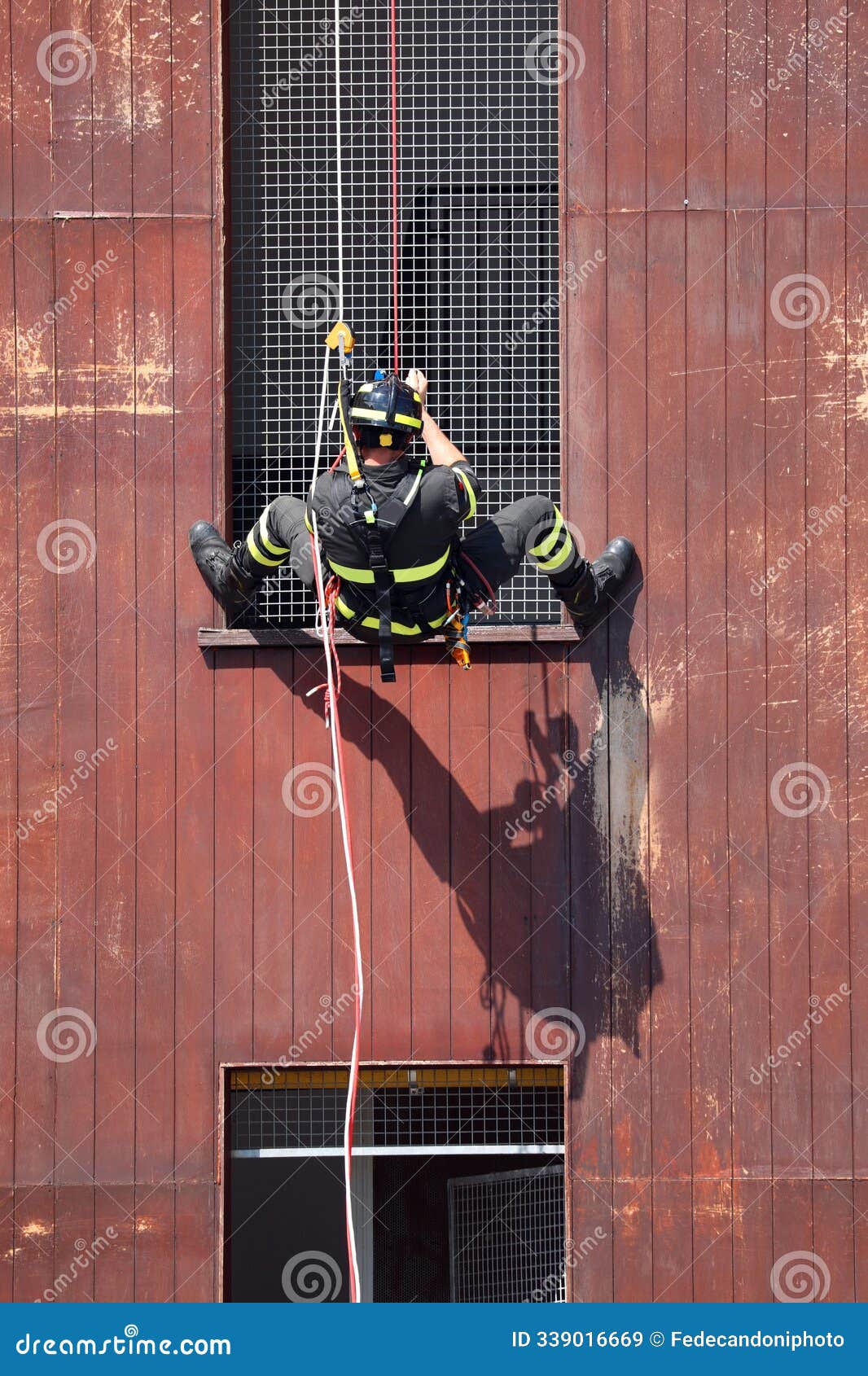 Firefighter Equipped with a Protective Helmet and Uniform is Rappelling ...