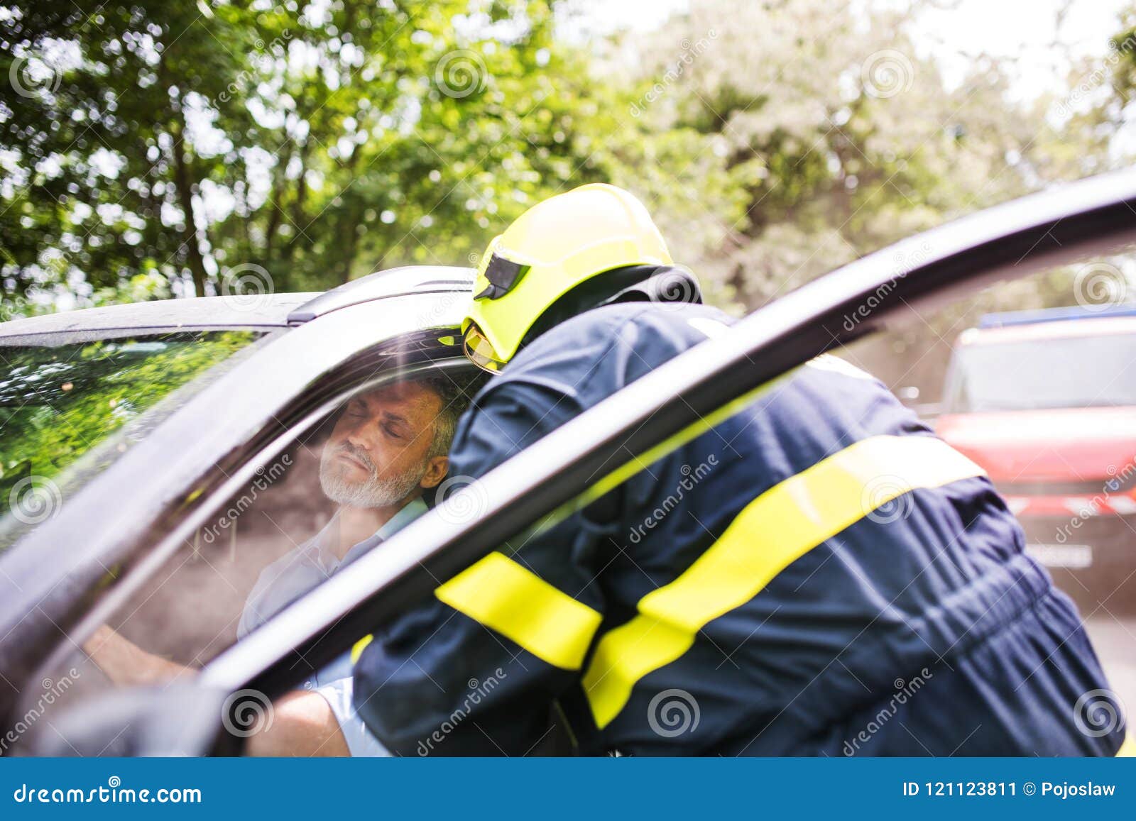 A Firefighter Getting an Unconscious Man Out of the Car after an ...