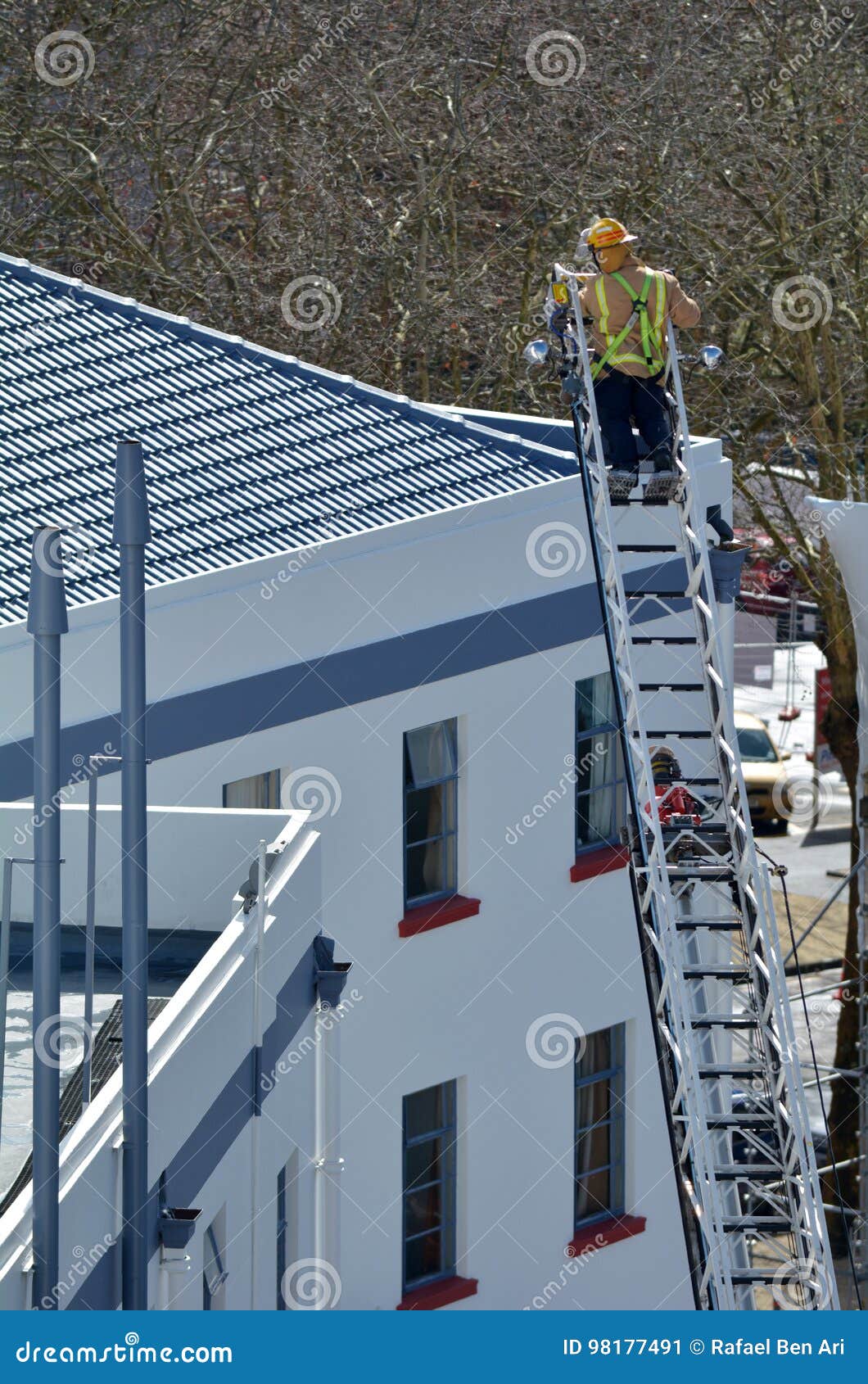 Firefighter On A Crane Lift Ladder Extinguish Flames Of A Burning ...