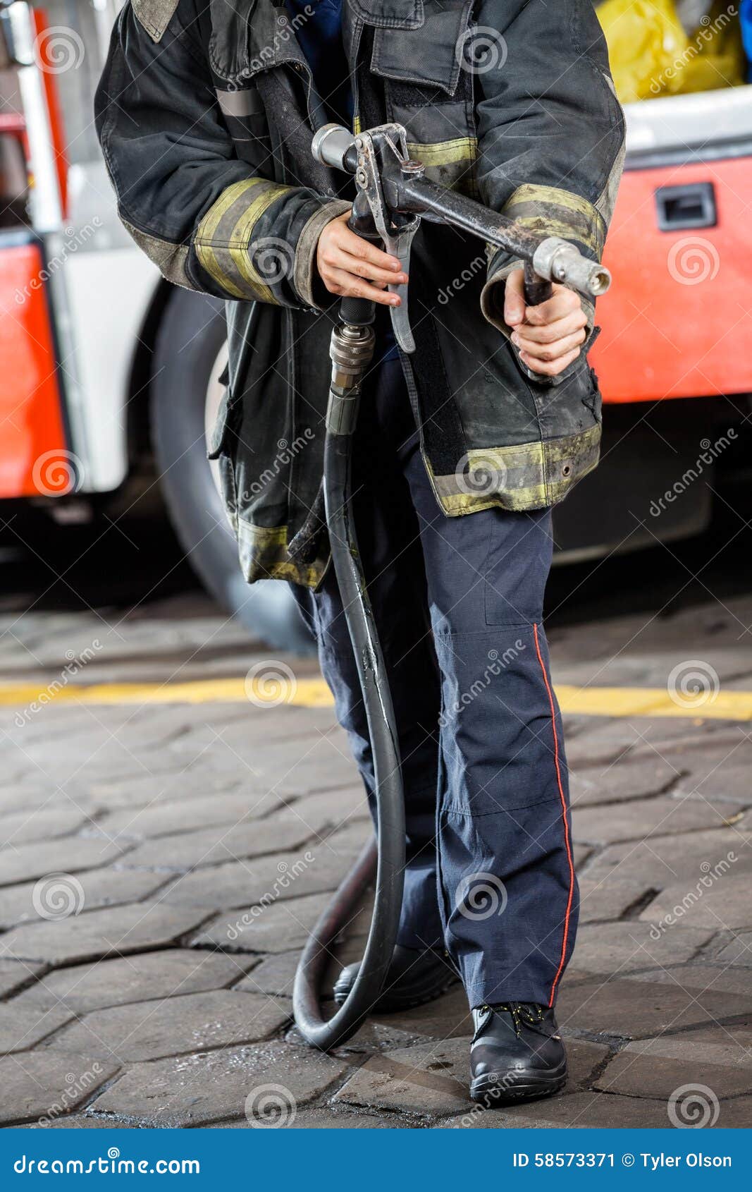 Firefighter Holding Water Hose at Fire Station Stock Image - Image of ...
