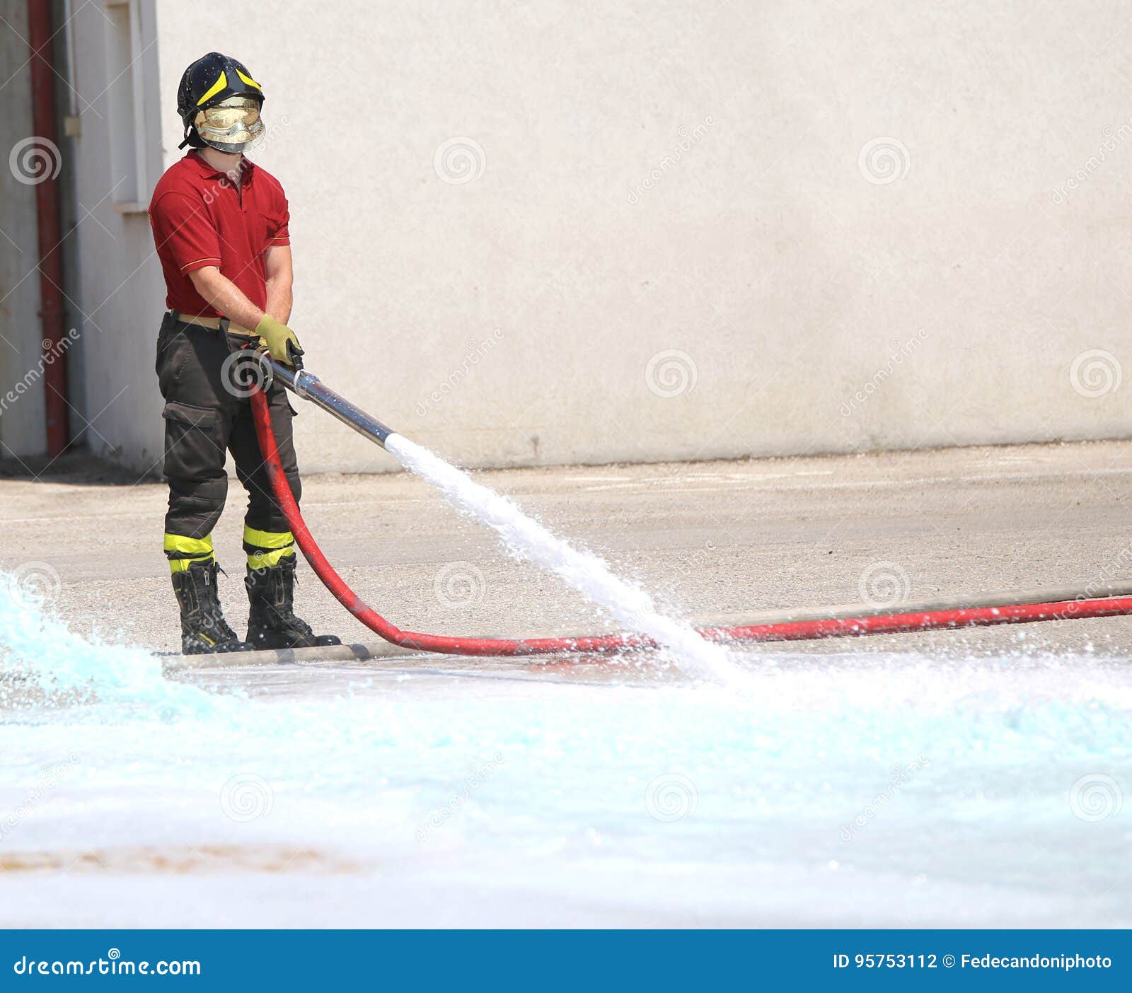 Firefighter With Hydrant In Action When Switching Off A Fire During ...