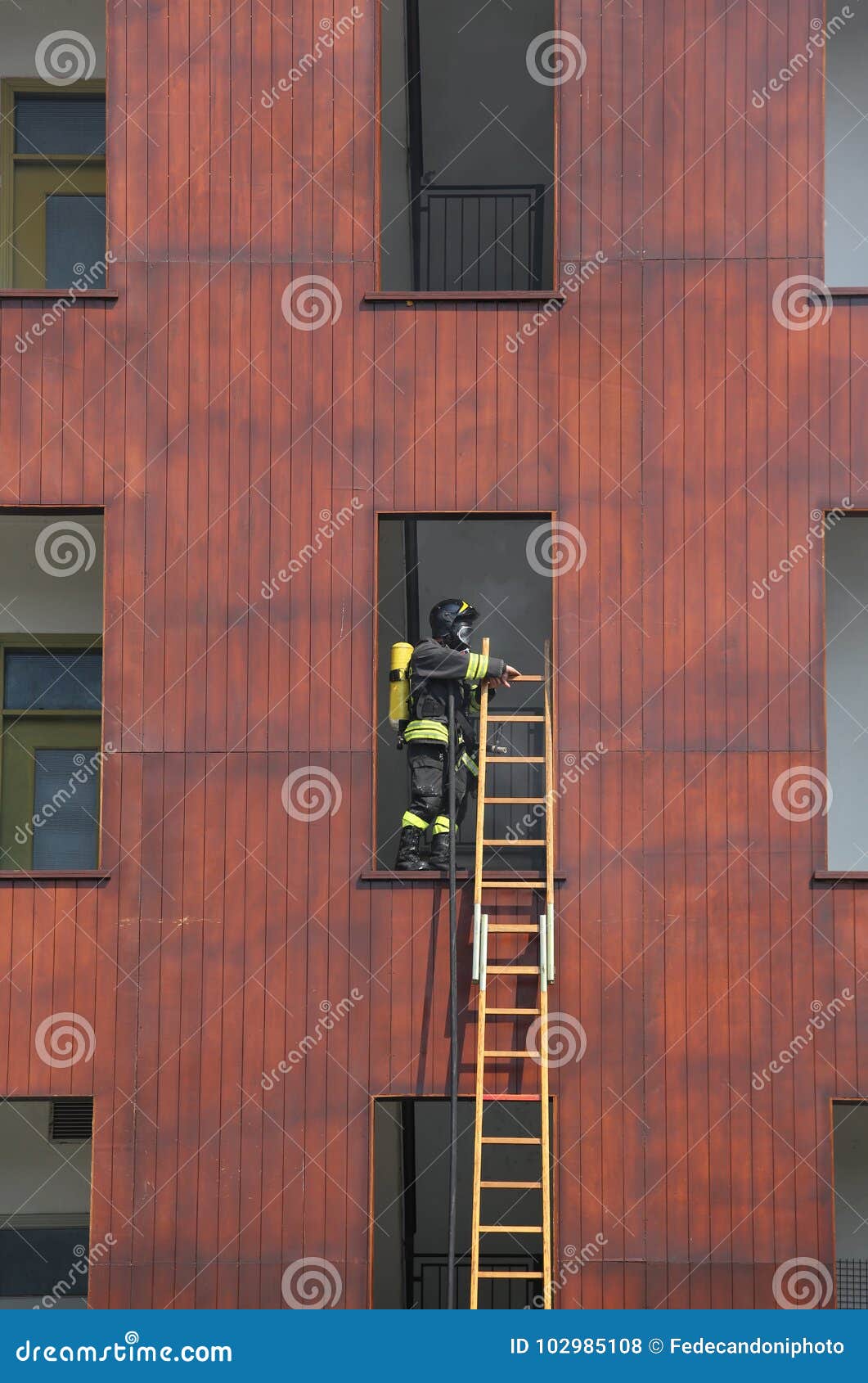 Firefighter with a Long Ladder with the Oxygen Cylinder Enters T ...