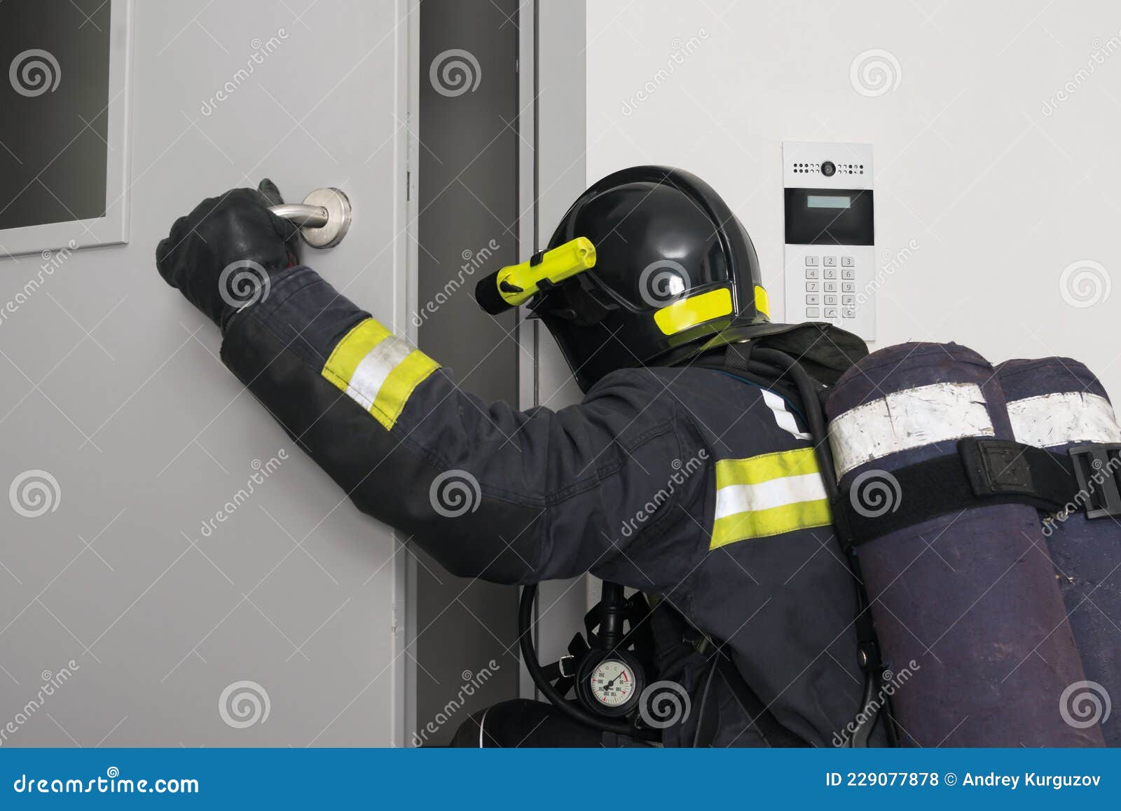 Firefighter Looking through an Open Iron Door, Rear View Stock Photo ...
