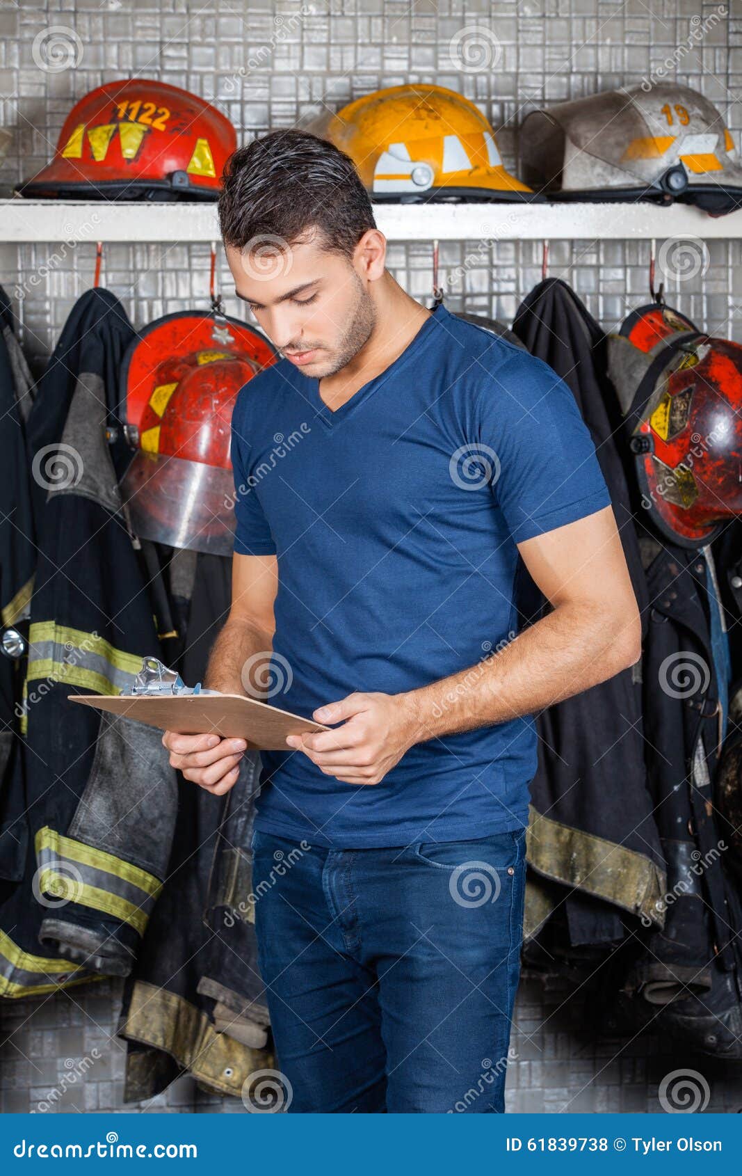 Firefighter Reading Clipboard at Fire Station Stock Photo - Image of ...