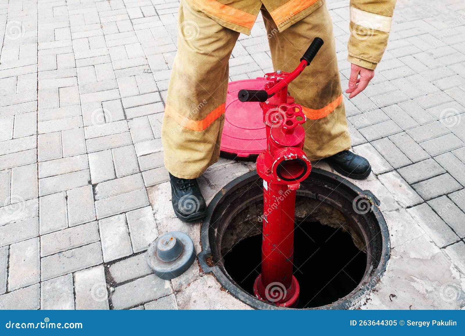 Firefighter or Rescuer Installs Fire Hydrant in Open Well. Fireman& X27 ...