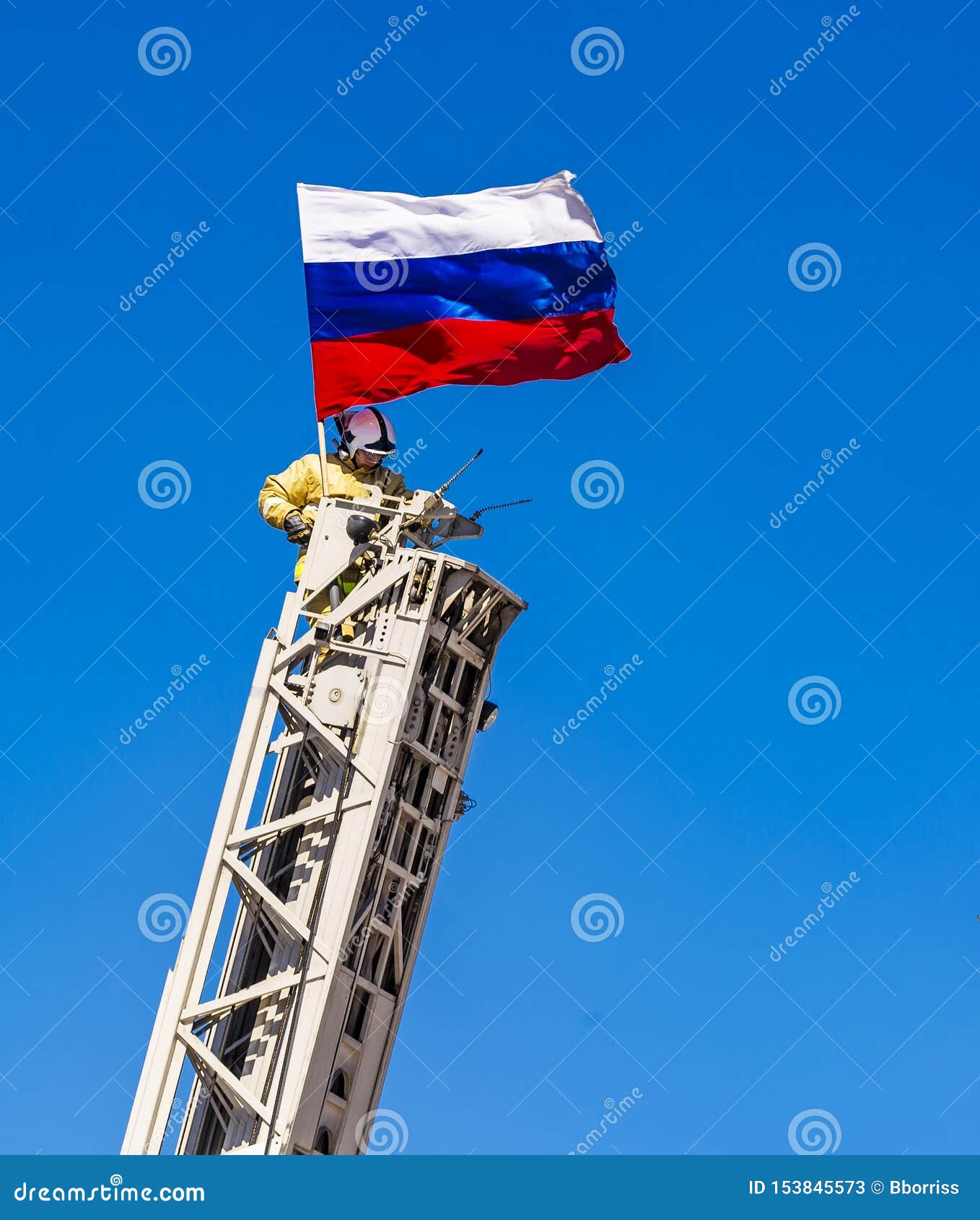 The Firefighter Secures a Russian Flag on the Fire Ladder on Background ...
