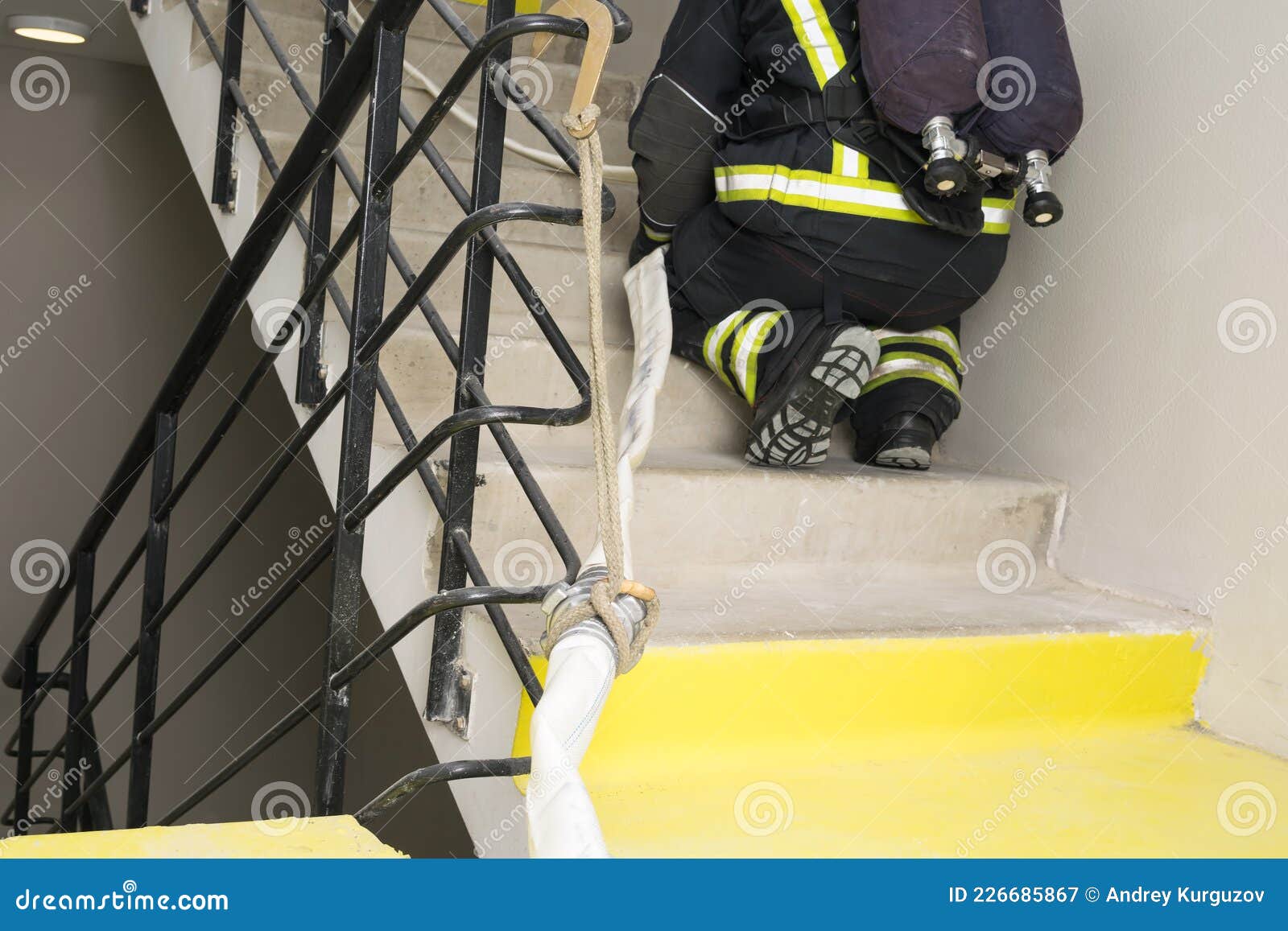 A Firefighter with Special Equipment Stretches a Line for Extinguishing ...