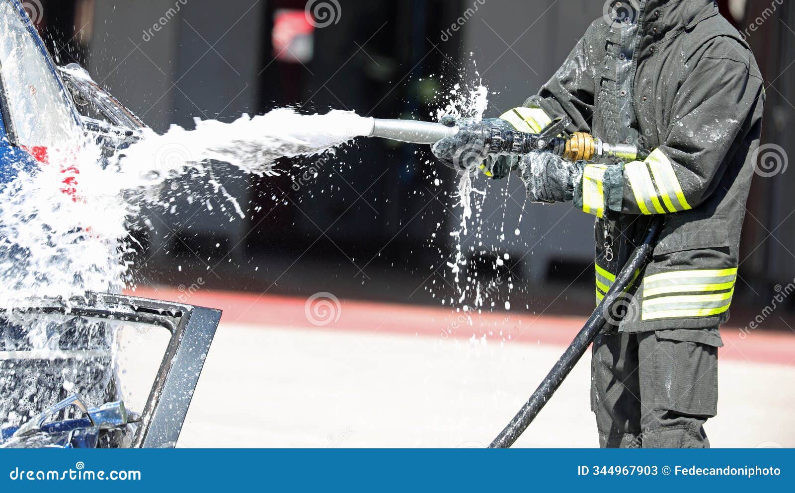 Firefighter in Uniform Spraying Fire Extinguishing Foam on a Damaged ...