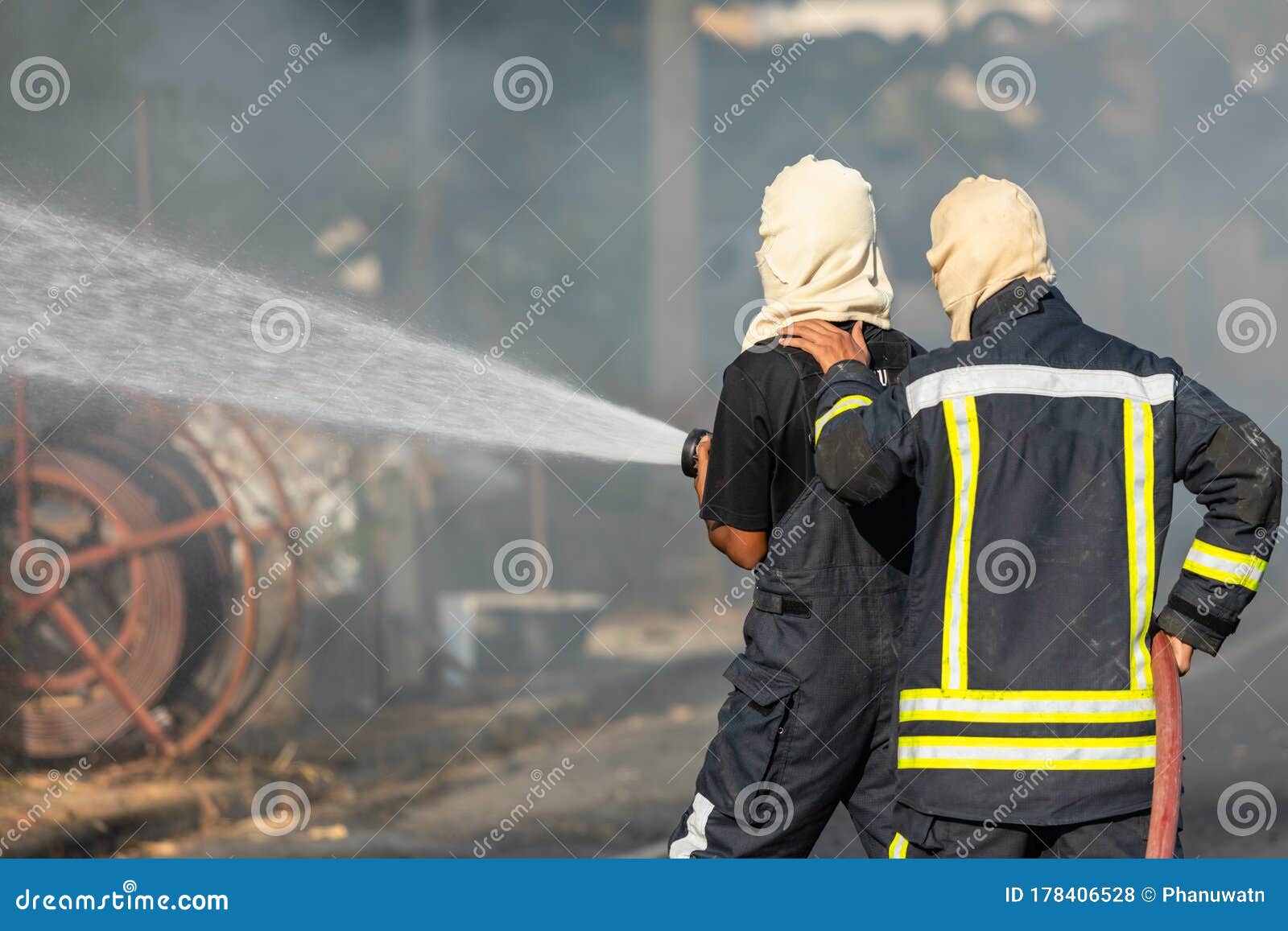 Firefighter Spraying Water from Big Water Hose To Prevent Fire Stock ...