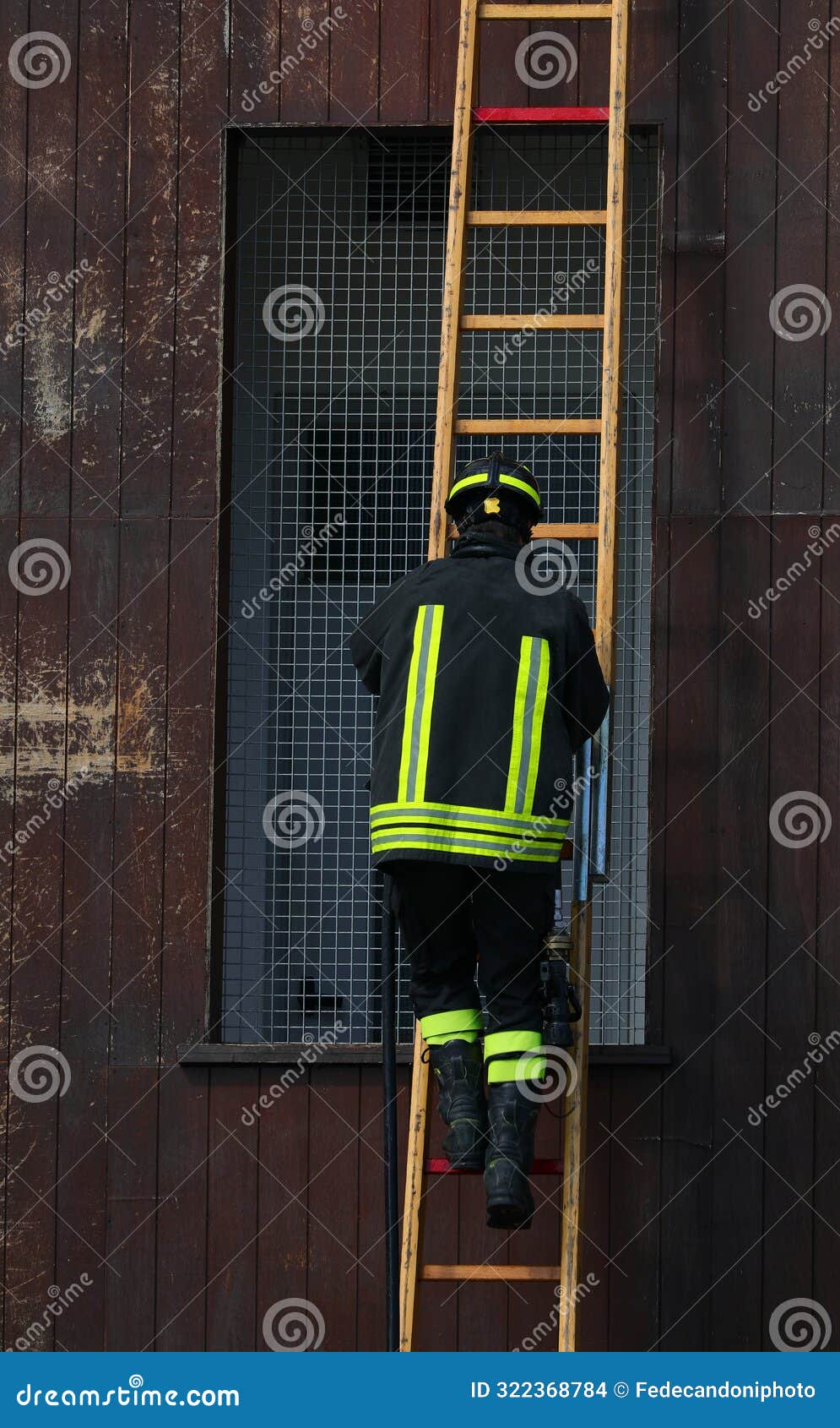 Firefighter in Uniform Climbing Ladder during Training at Fire Station ...