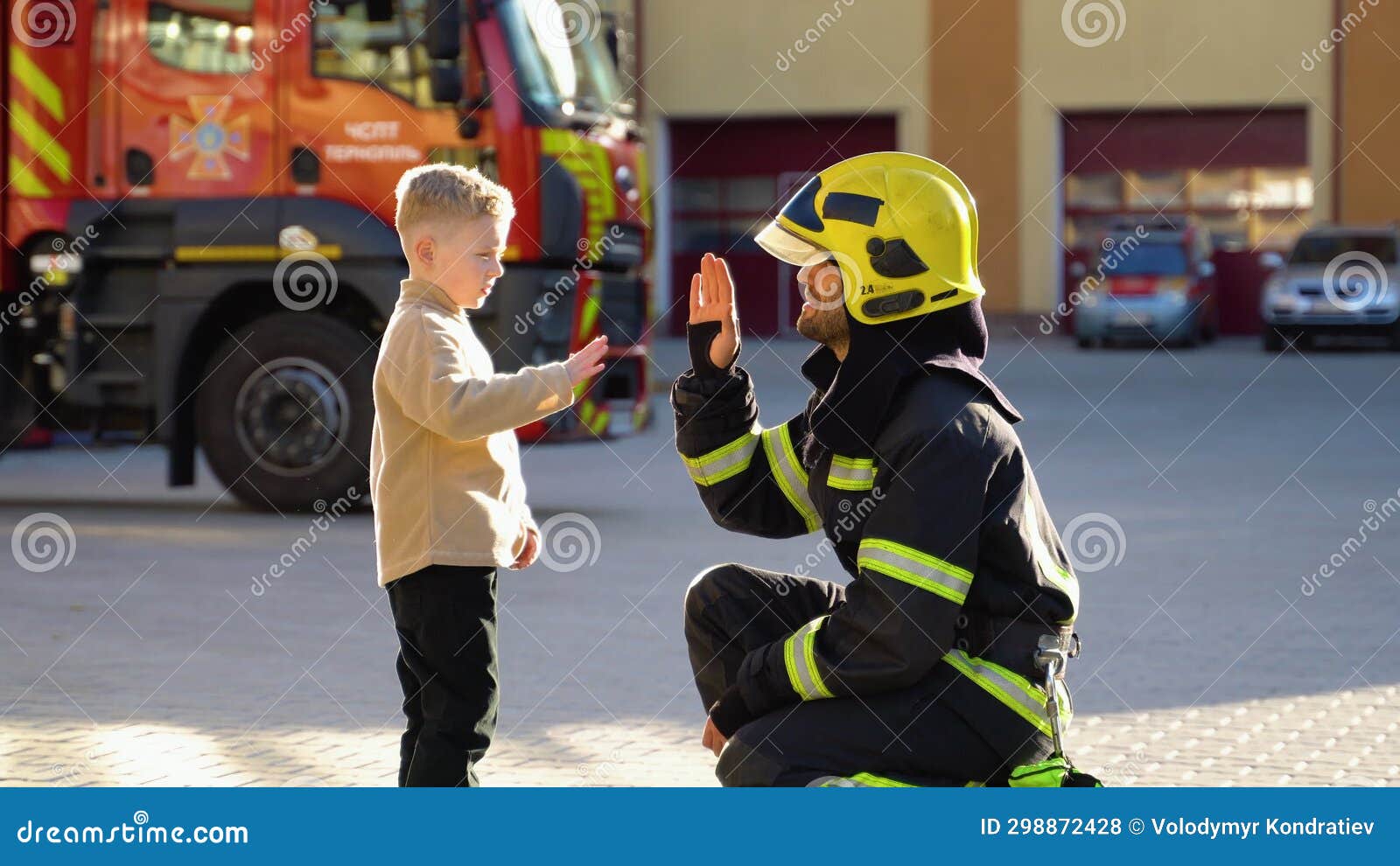 Firefighter in Uniform is with a Little Boy at Fire Station Stock ...