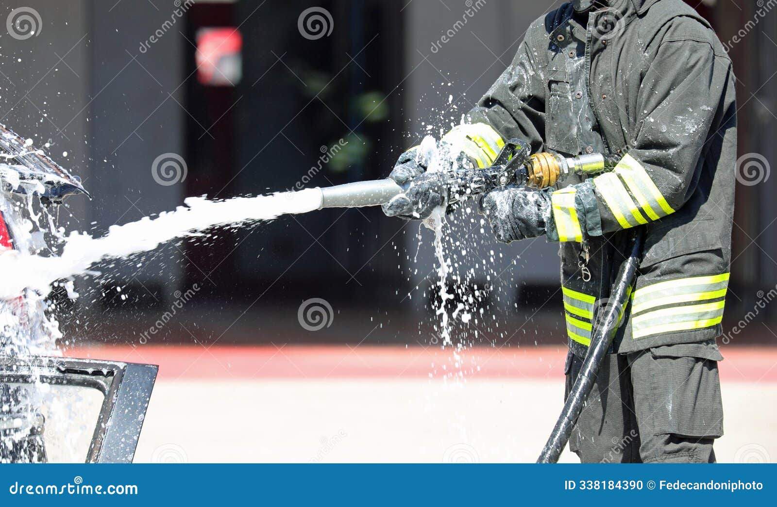Firefighter Using a Hose To Spray Foam on a Fire during an Urban ...