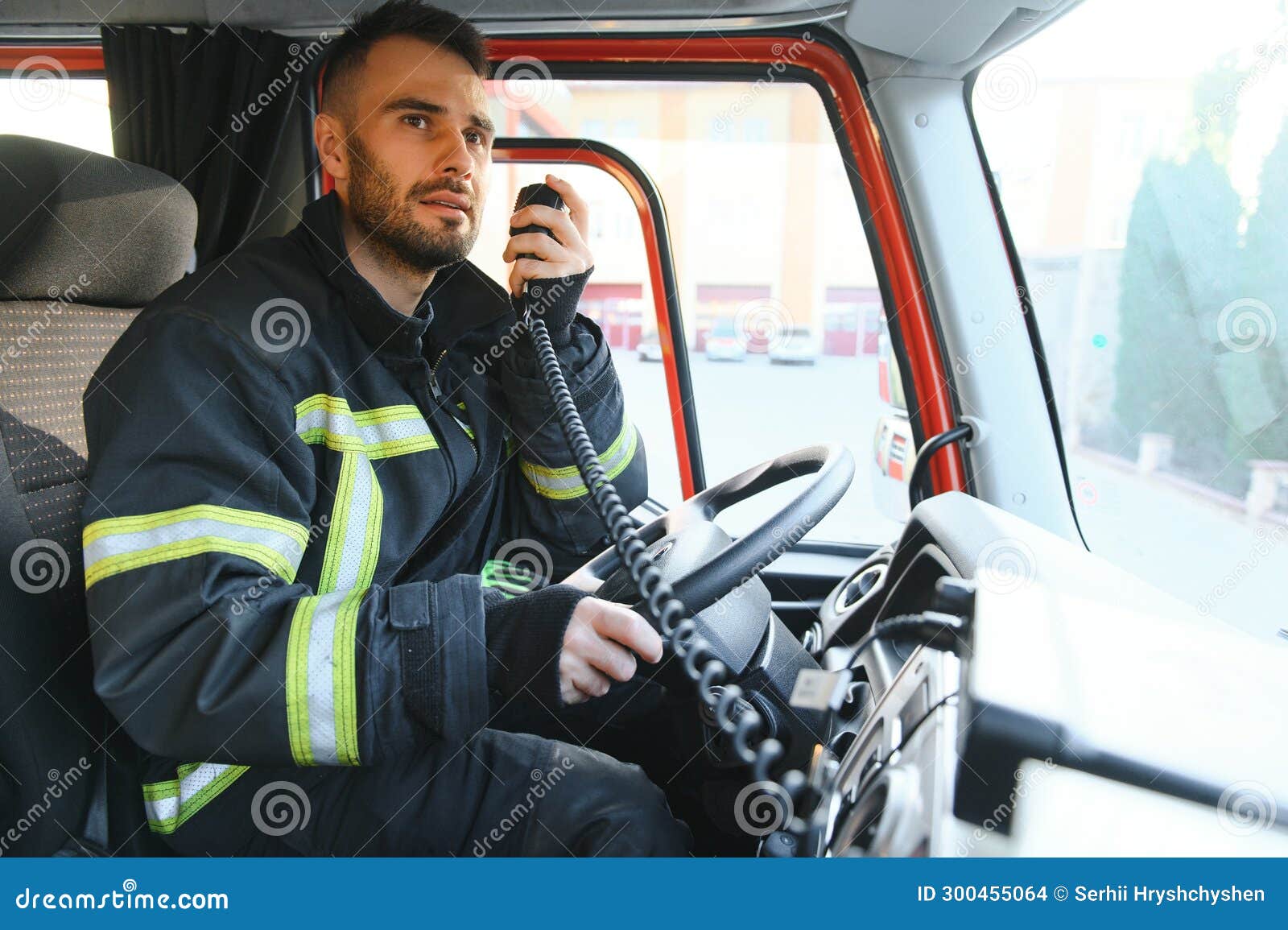Firefighter Using Radio Set while Driving Fire Truck Stock Photo ...