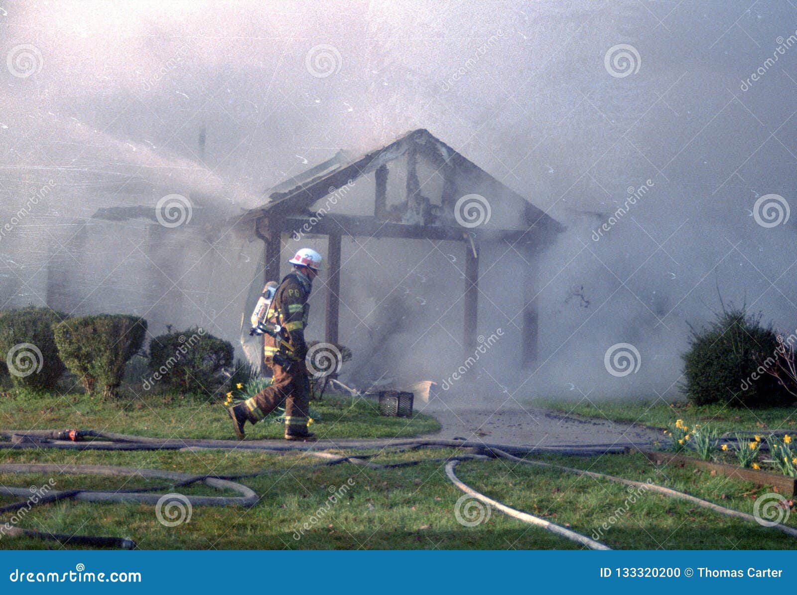 A Firefighter Walks in Front of a Building that is Onm Fire Editorial ...