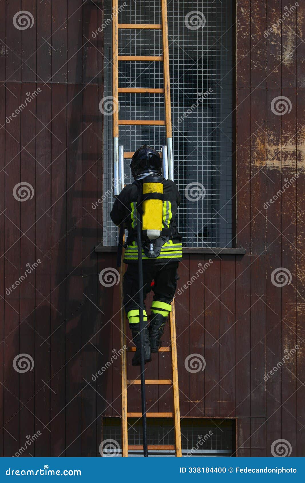 Firefighter Wearing an Oxygen Tank Climbs a Ladder during a Training ...