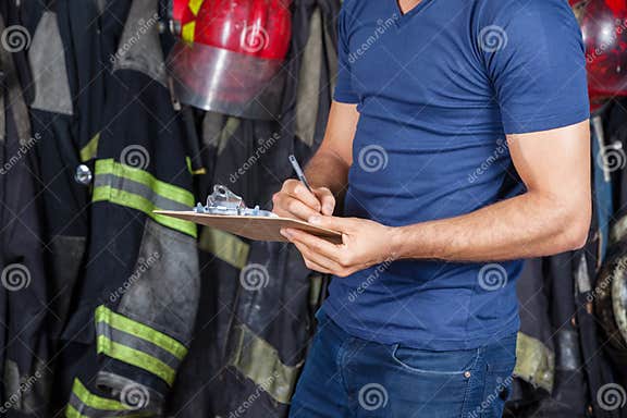Firefighter Writing on Clipboard Stock Image - Image of fireman ...