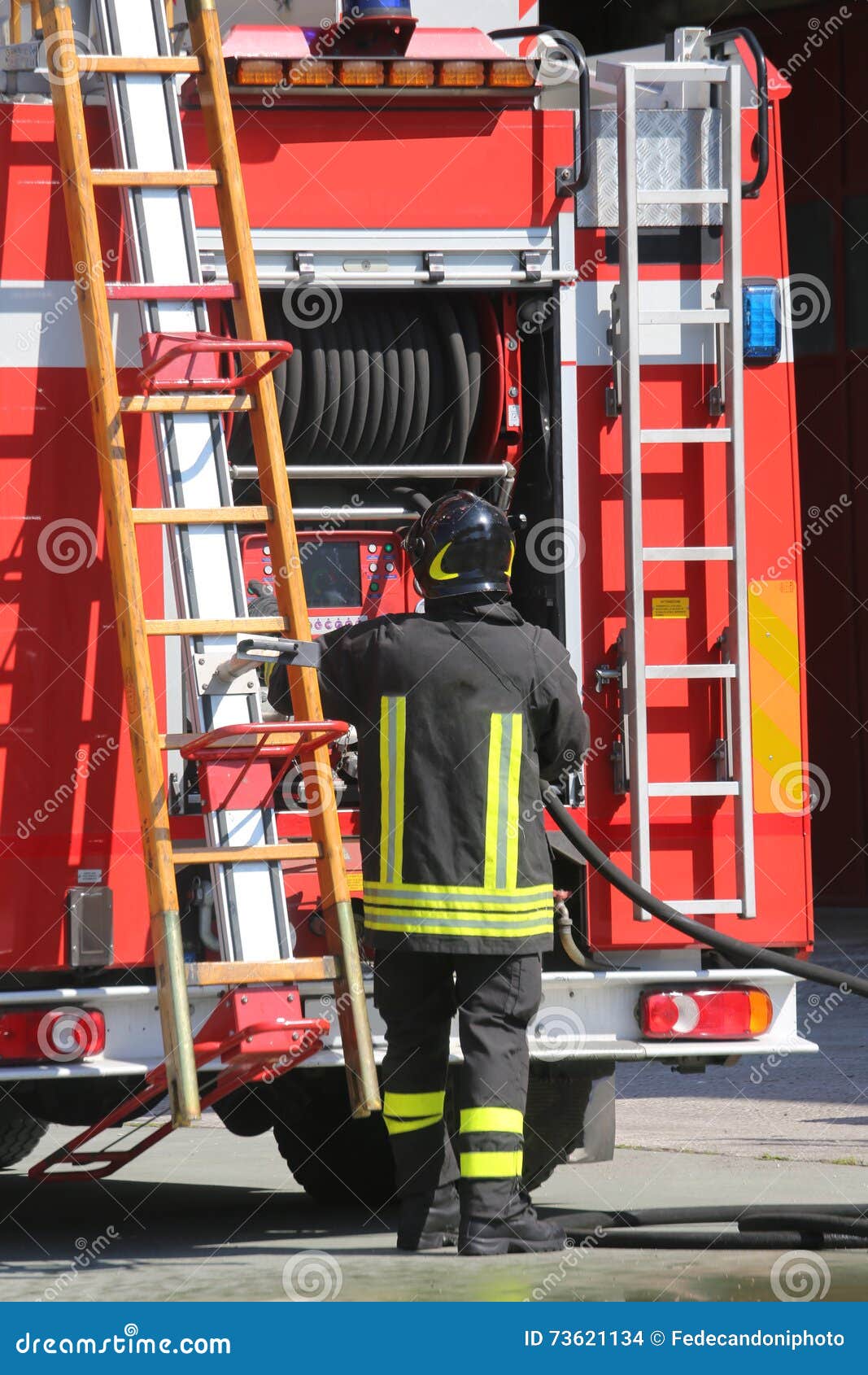 Firefighters in Action Take the Ladder from the Fire Engine Stock Photo ...