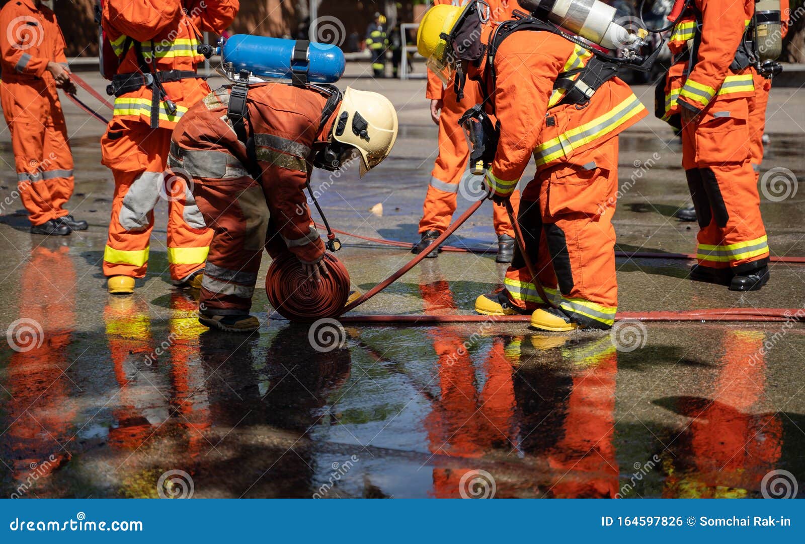 Firefighters in Fireproof Uniform and Keeping Fire Hose after Fighting ...