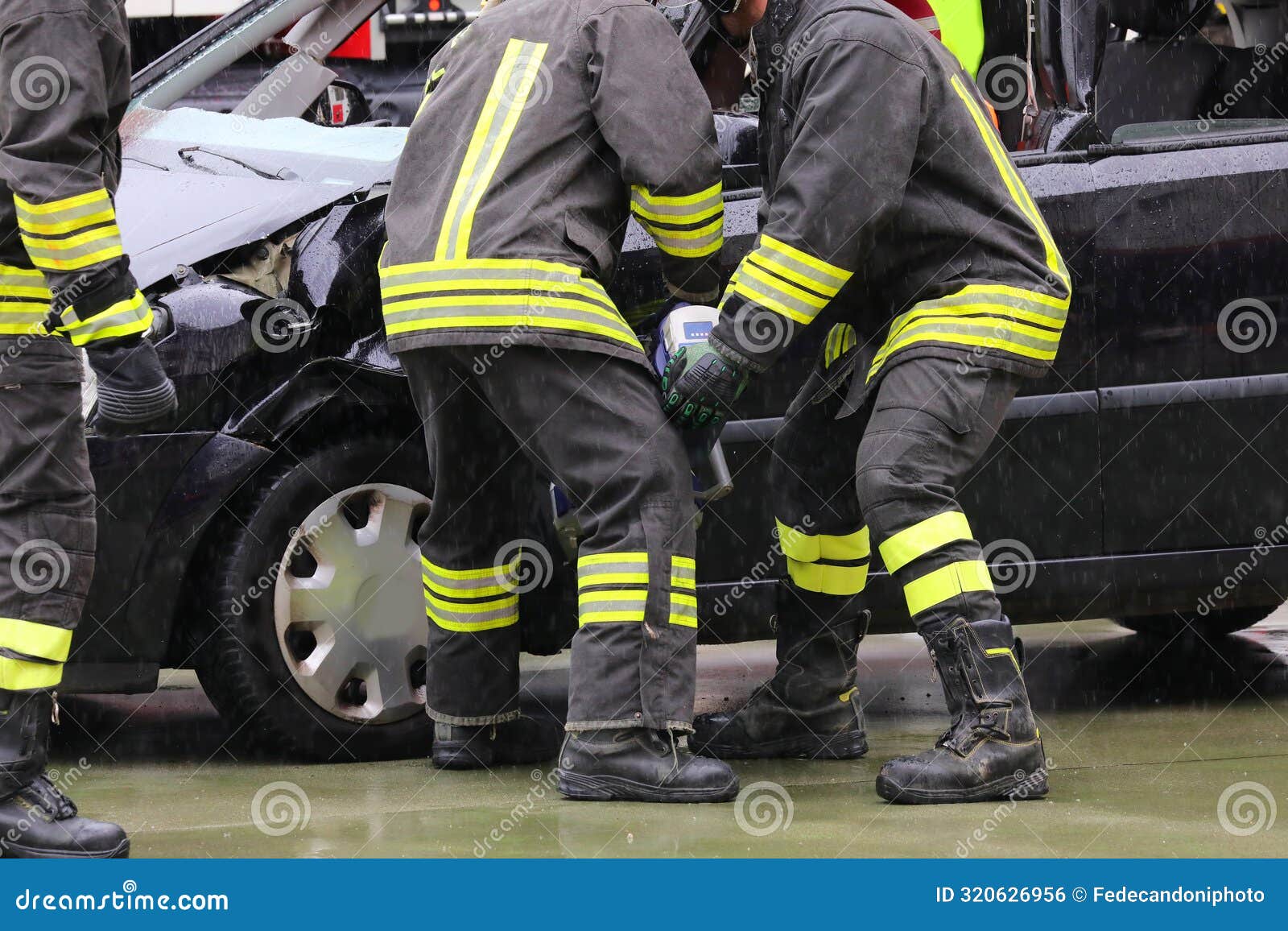 Firefighters Unhinging the Stuck Door of a Crashed Car after the ...