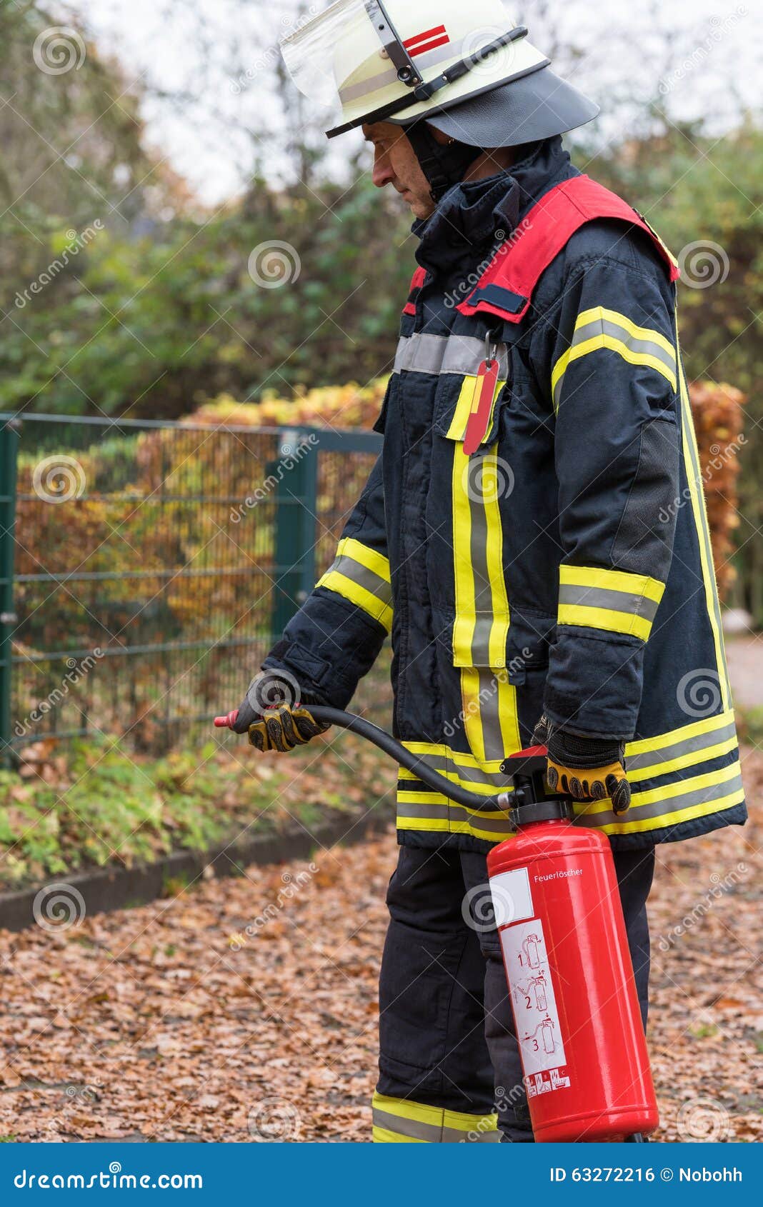 Fireman in Action with a Fire Extinguisher Stock Photo - Image of marsh ...
