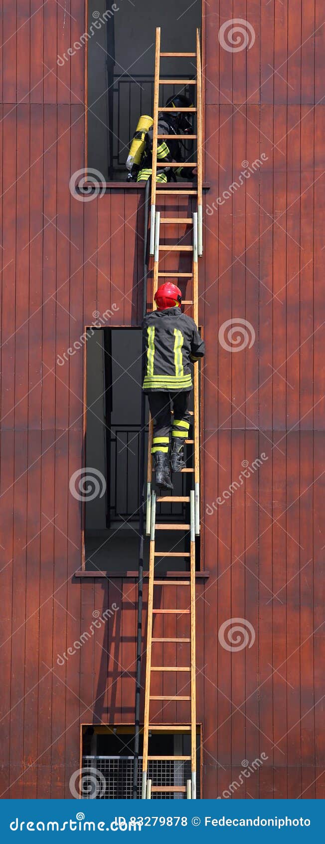 Fireman Climbs Up the Ladder during a Training Exercise Stock Photo ...