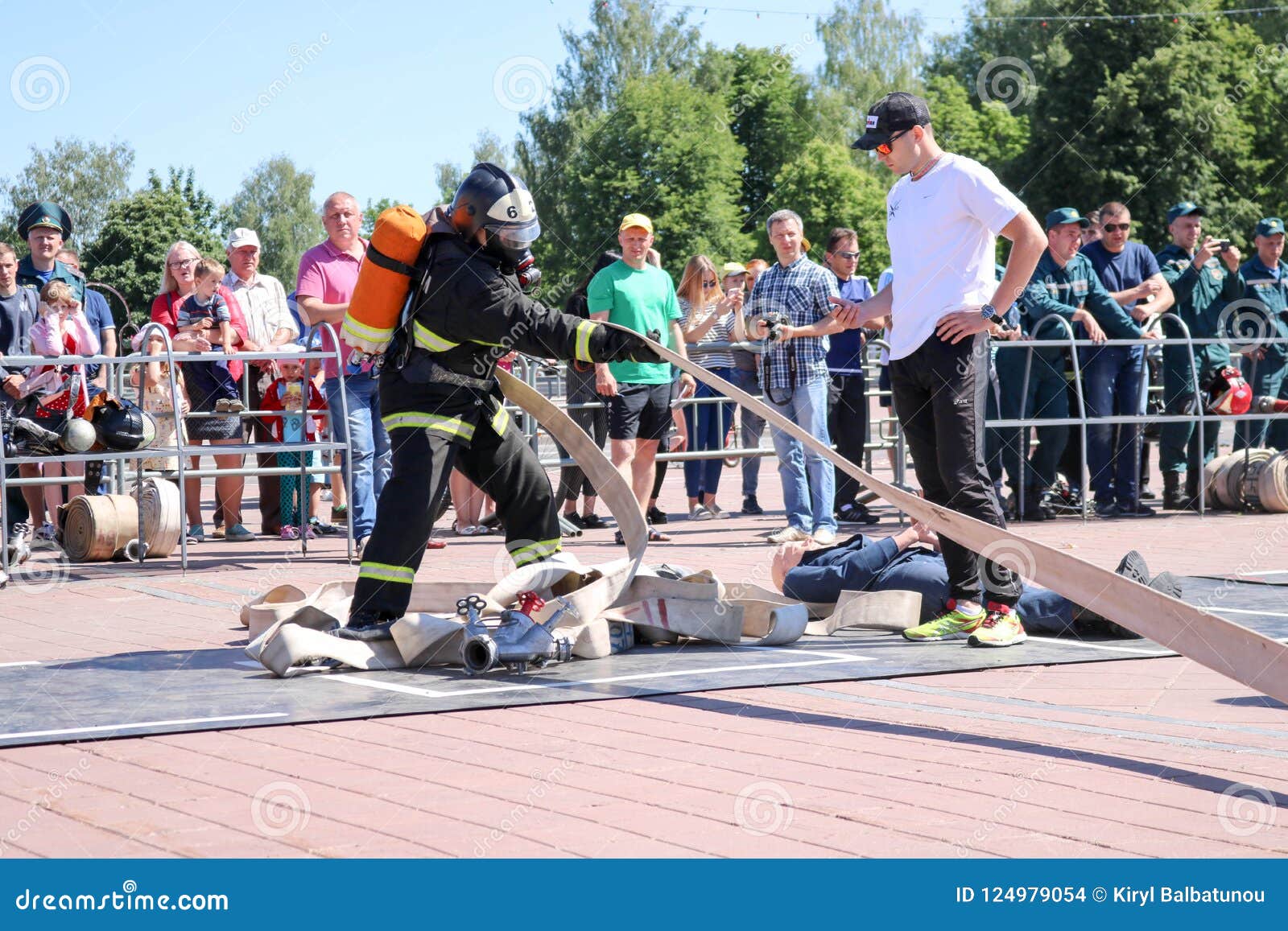 A Fireman in a Fireproof Suit and a Helmet Holding a Fire Hose at a ...