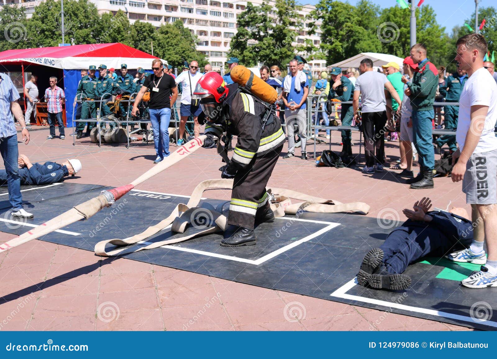 A Fireman in a Fireproof Suit and a Helmet Holding a Fire Hose at a ...
