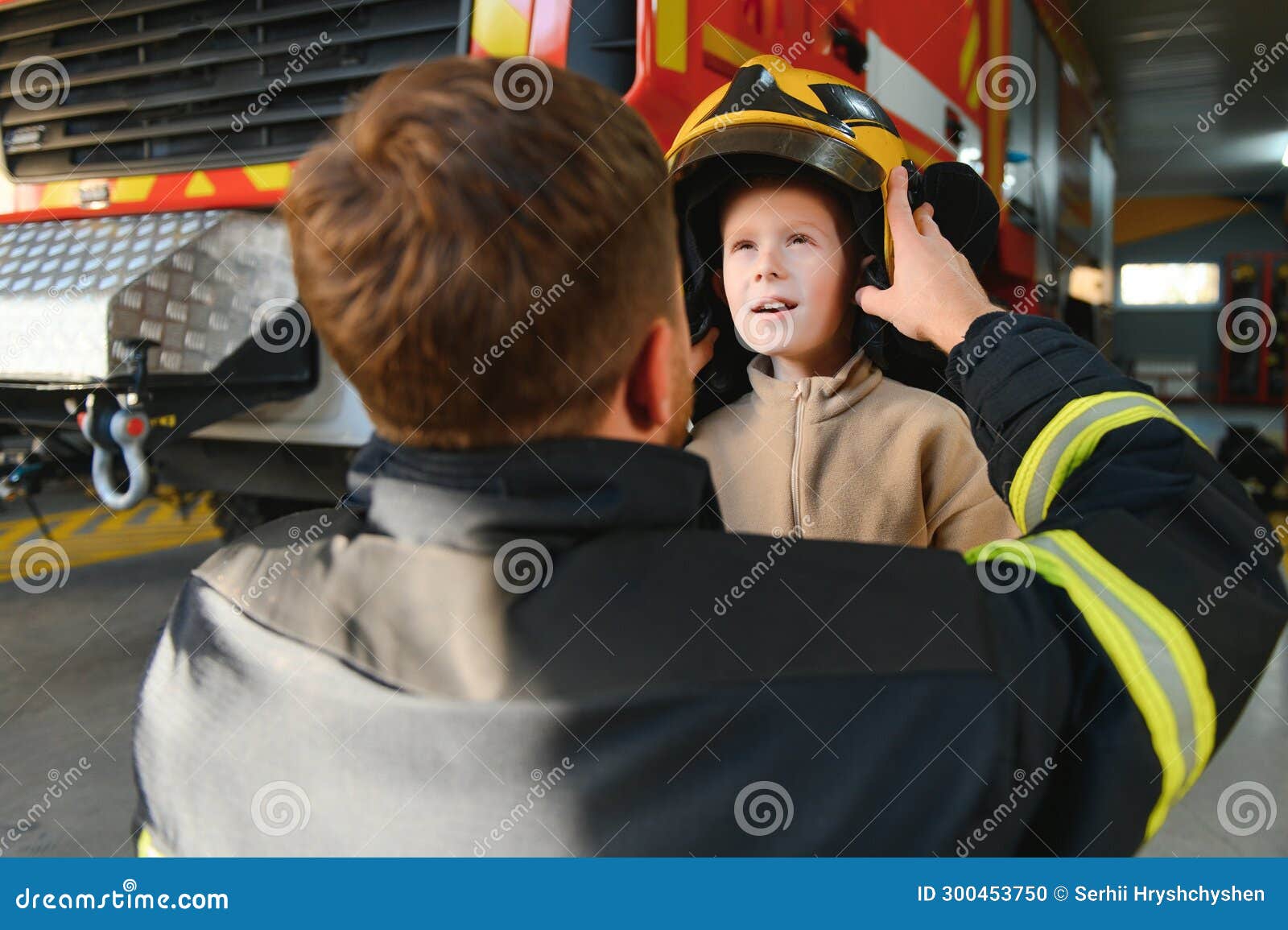 A Fireman Shows His Work To His Young Son. a Boy in a Firefighter& X27 ...