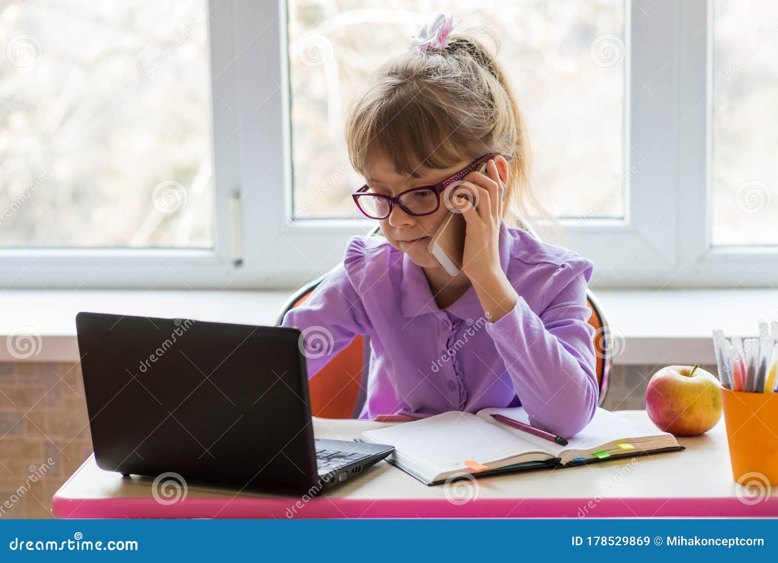 First-grader Sits at a Table Talking on the Phone and Learns Remotely ...