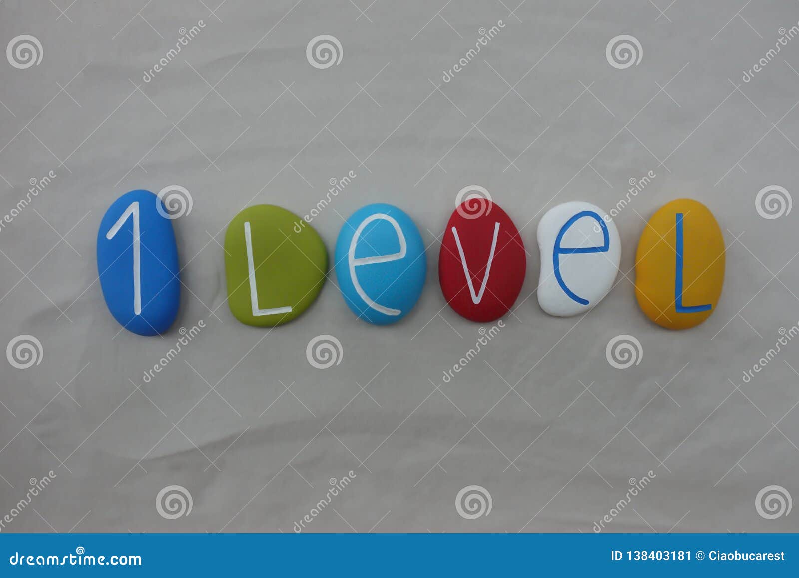 First Level Text Composed with Multi Colored Stones Over White Sand ...