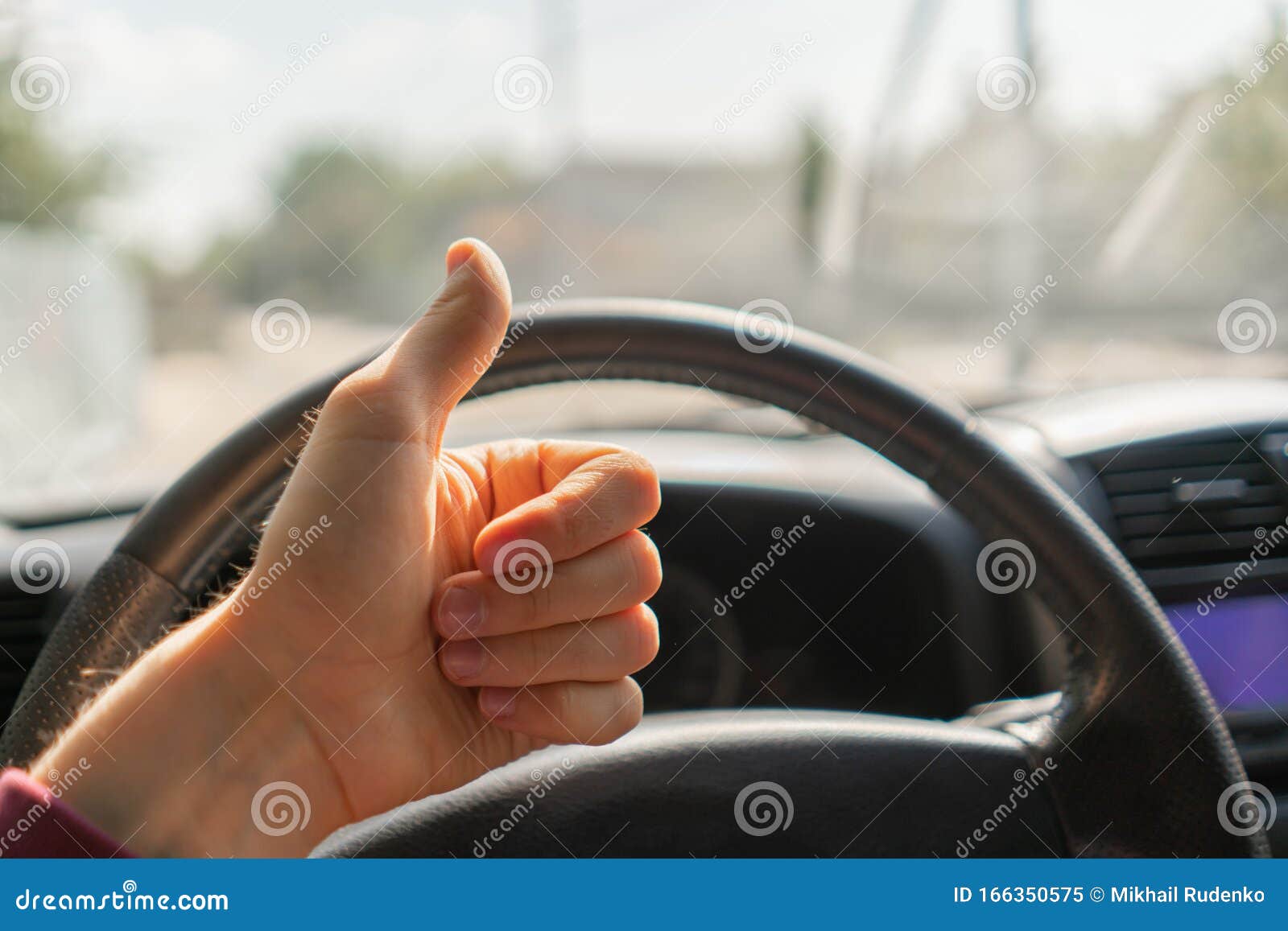 A First Person View of Driver Showing Thumb Up in Front of Steering ...