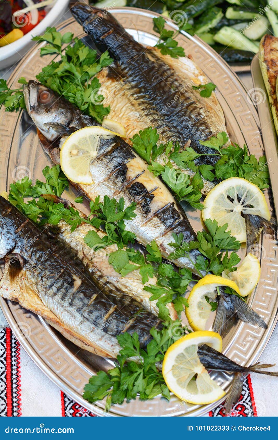 Fish Cooked on Fire on a Plate with Leaves Parsley and Lemon. Stock ...