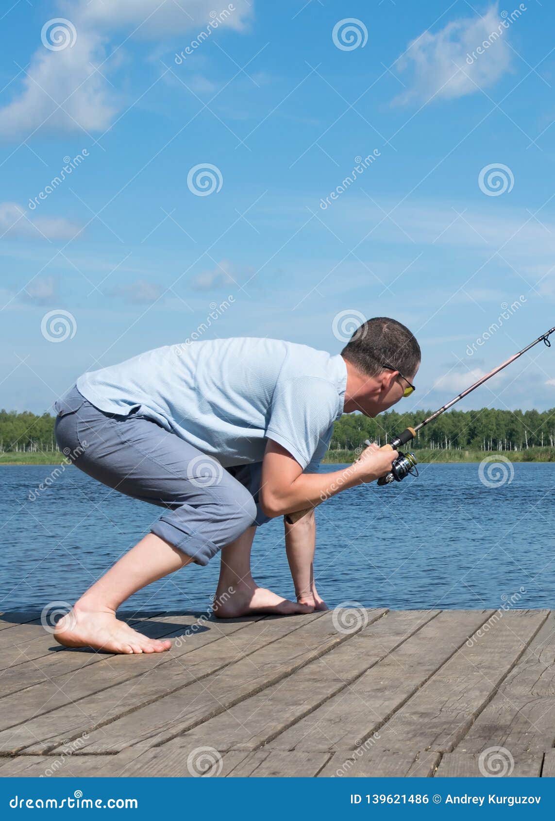 Fisherman Caught a Big Fish and Wants To Pull it Out of the Water, Rear ...