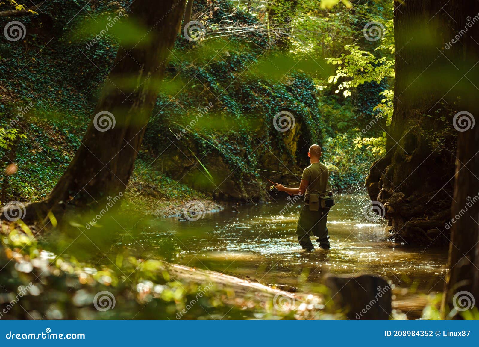 A Fisherman Fishing in the Flowing Stream Stock Photo - Image of ...