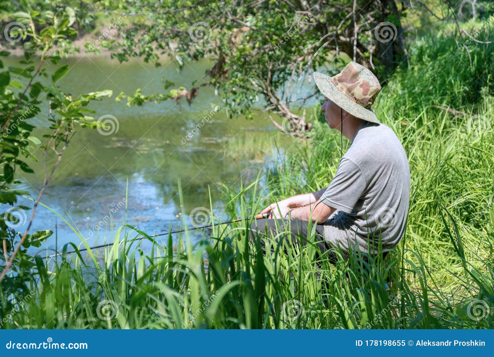 Fisherman in a Hat is Fishing on a Forest Lake or River Stock Image ...