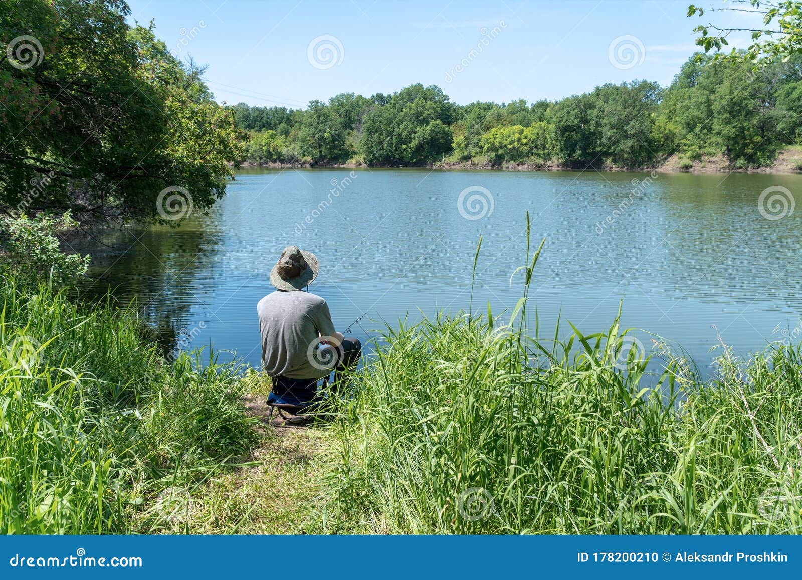 Fisherman in a Hat is Fishing on a Forest Lake or River Stock Photo ...