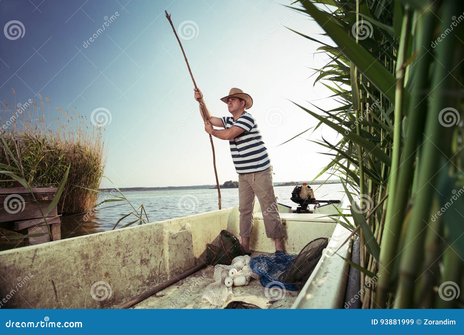 Fisherman Pushing Boat from the River Bank Stock Image - Image of ...