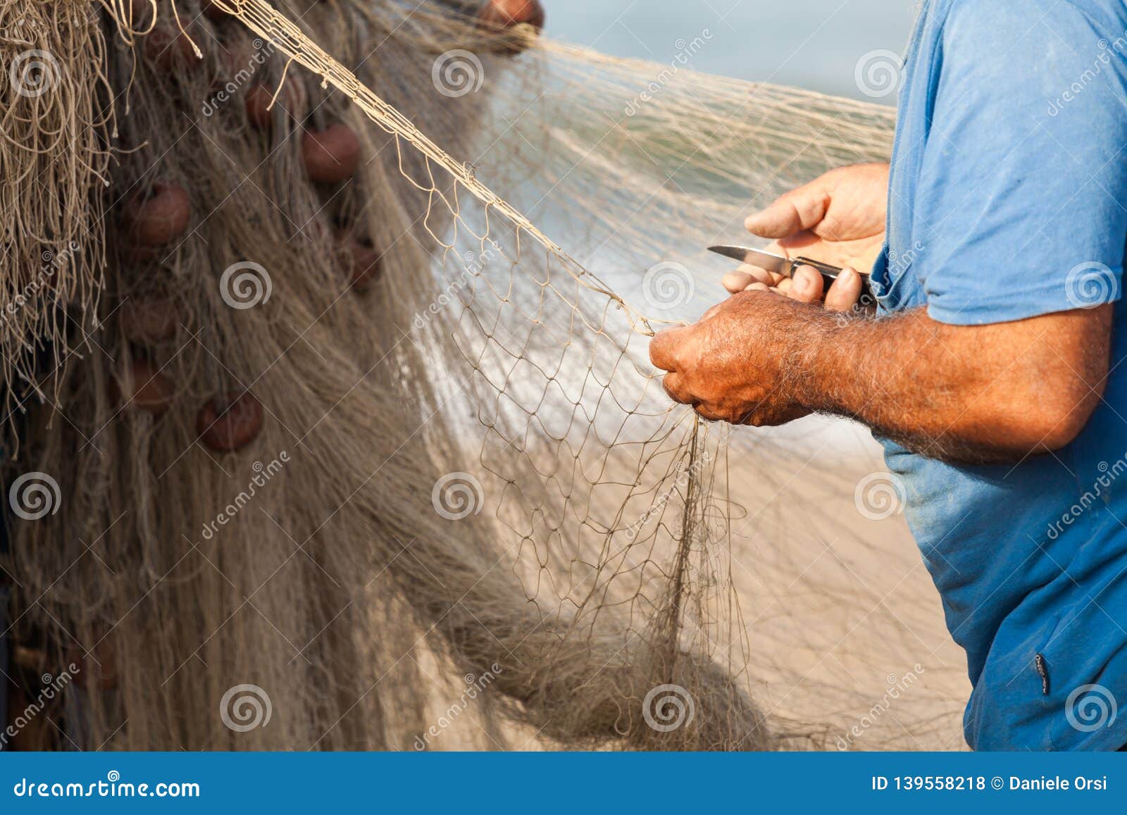 Fisherman is Settings Up His Fishing Net at the Beach Stock Photo ...