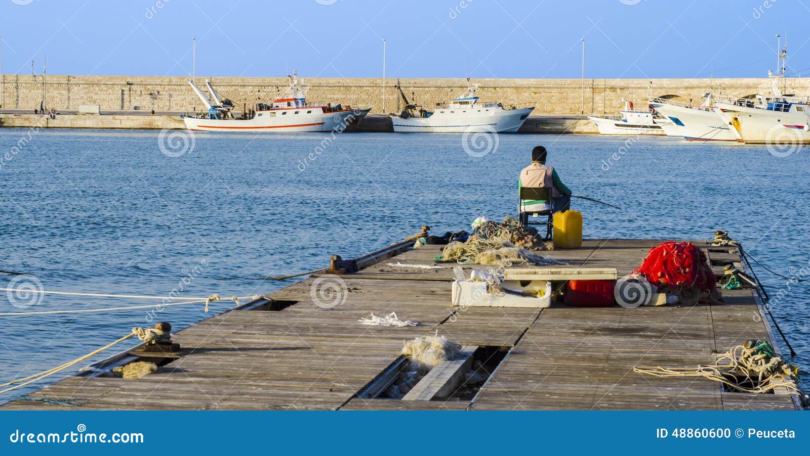 Fisherman Sitting on the Dock of a Harbor Italian Stock Photo - Image ...