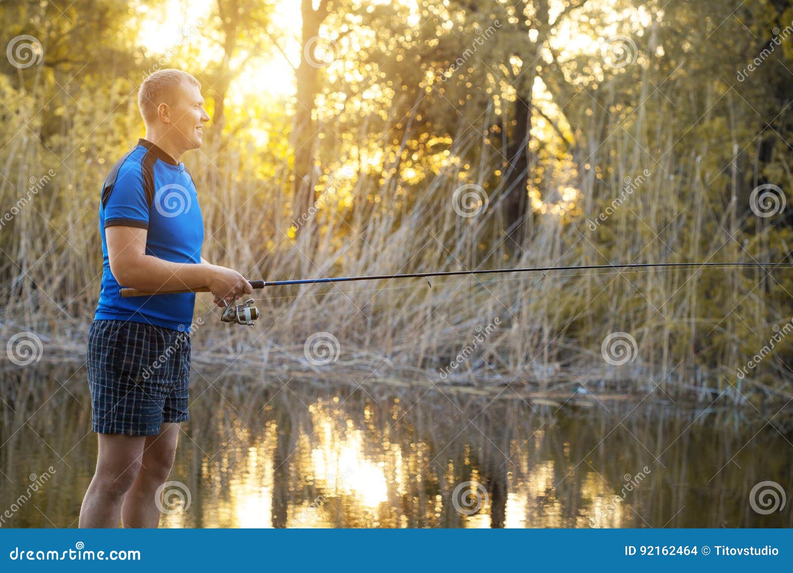 Fisherman with a Spinning Rod Catching Fish on a River. Stock Photo ...