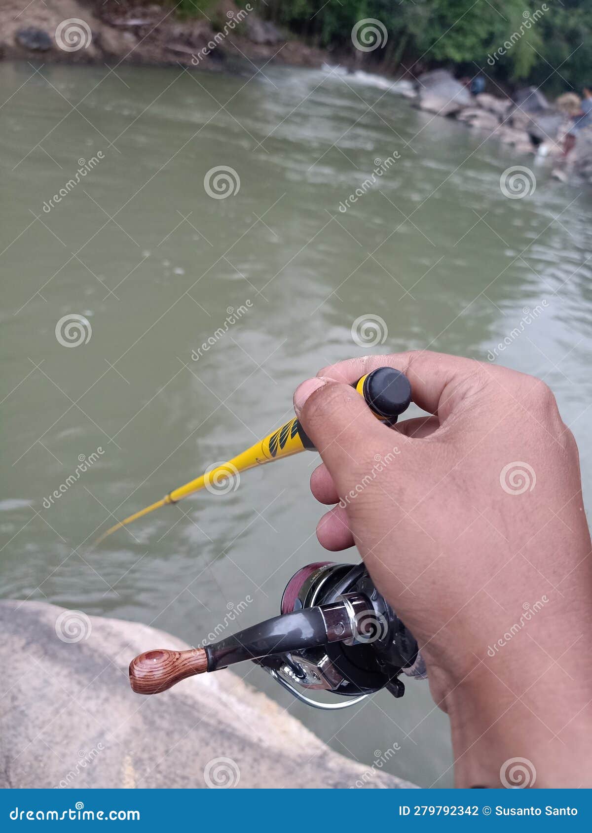 Fishing for Fish Using a Yellow Rod with a String Reel in the River ...