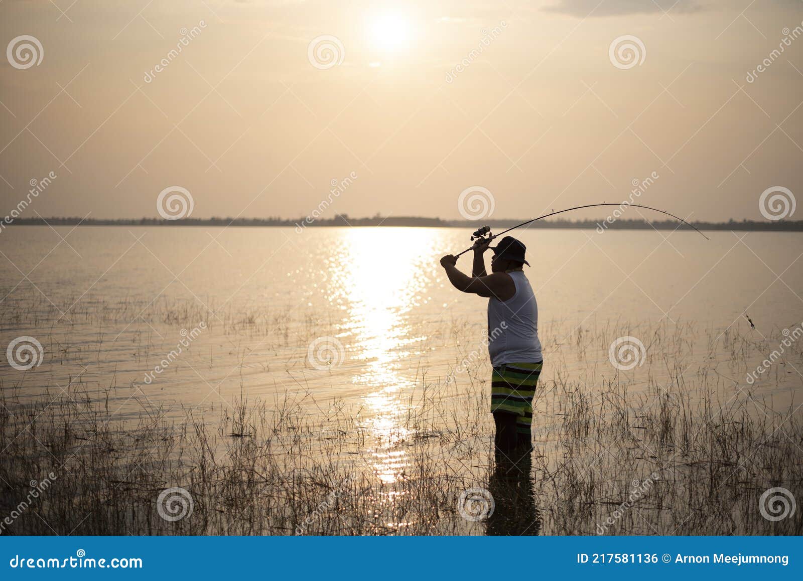 Fishing man at sunset. stock photo. Image of beach, reflection - 217581136